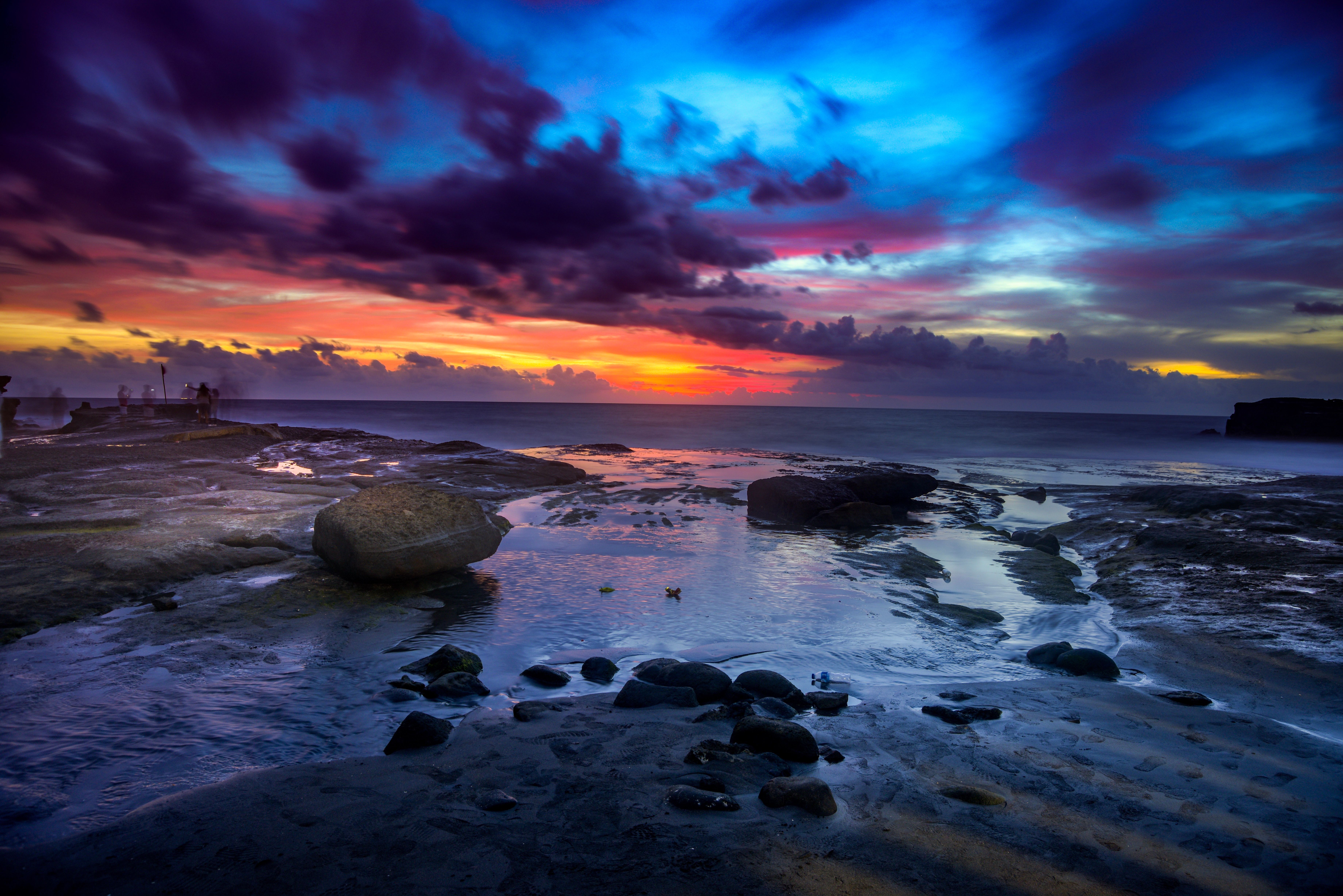 Sunset under Clouds over Rocks on Sea Shore · Free Stock Photo