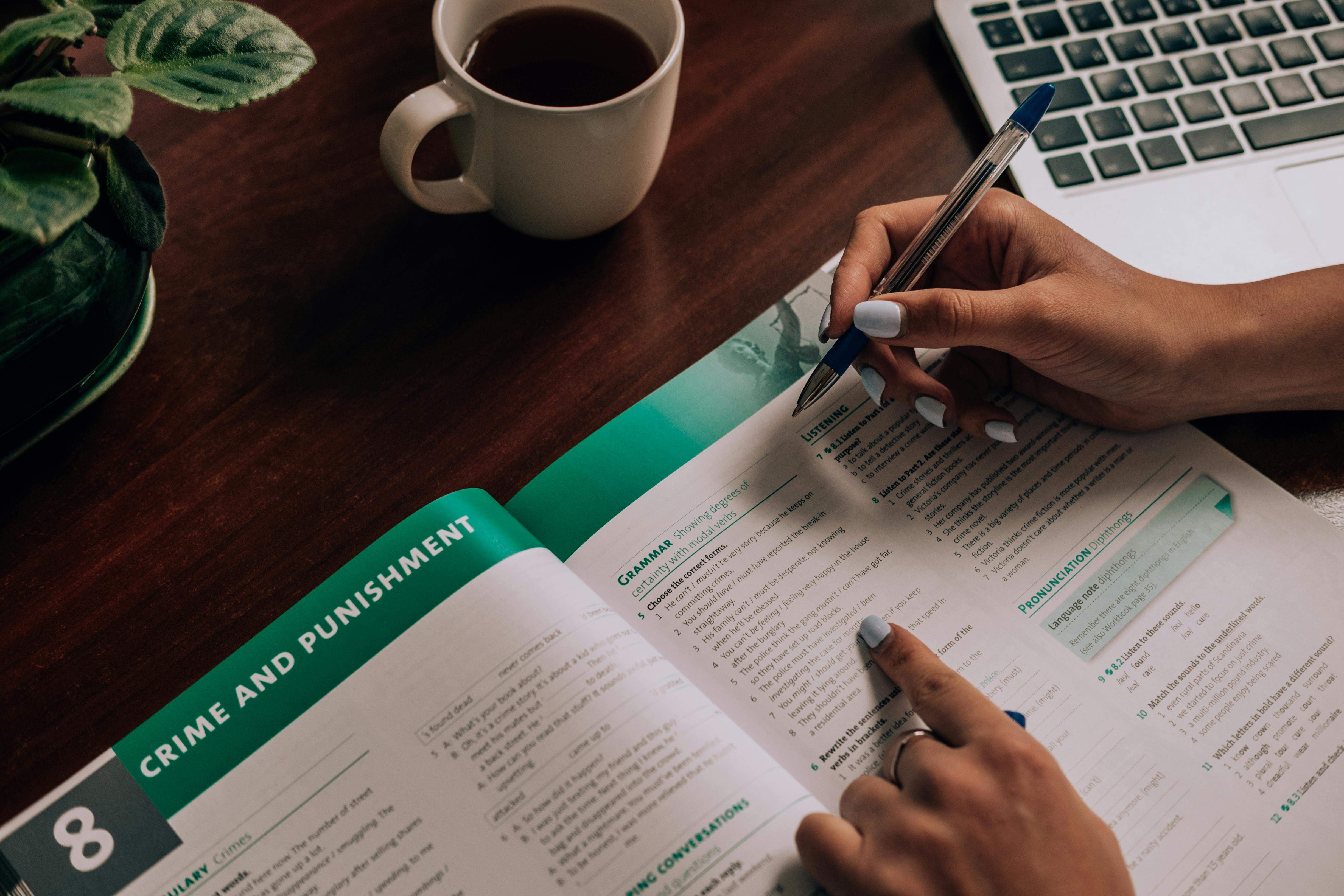 Crop woman doing tasks in textbook · Free Stock Photo