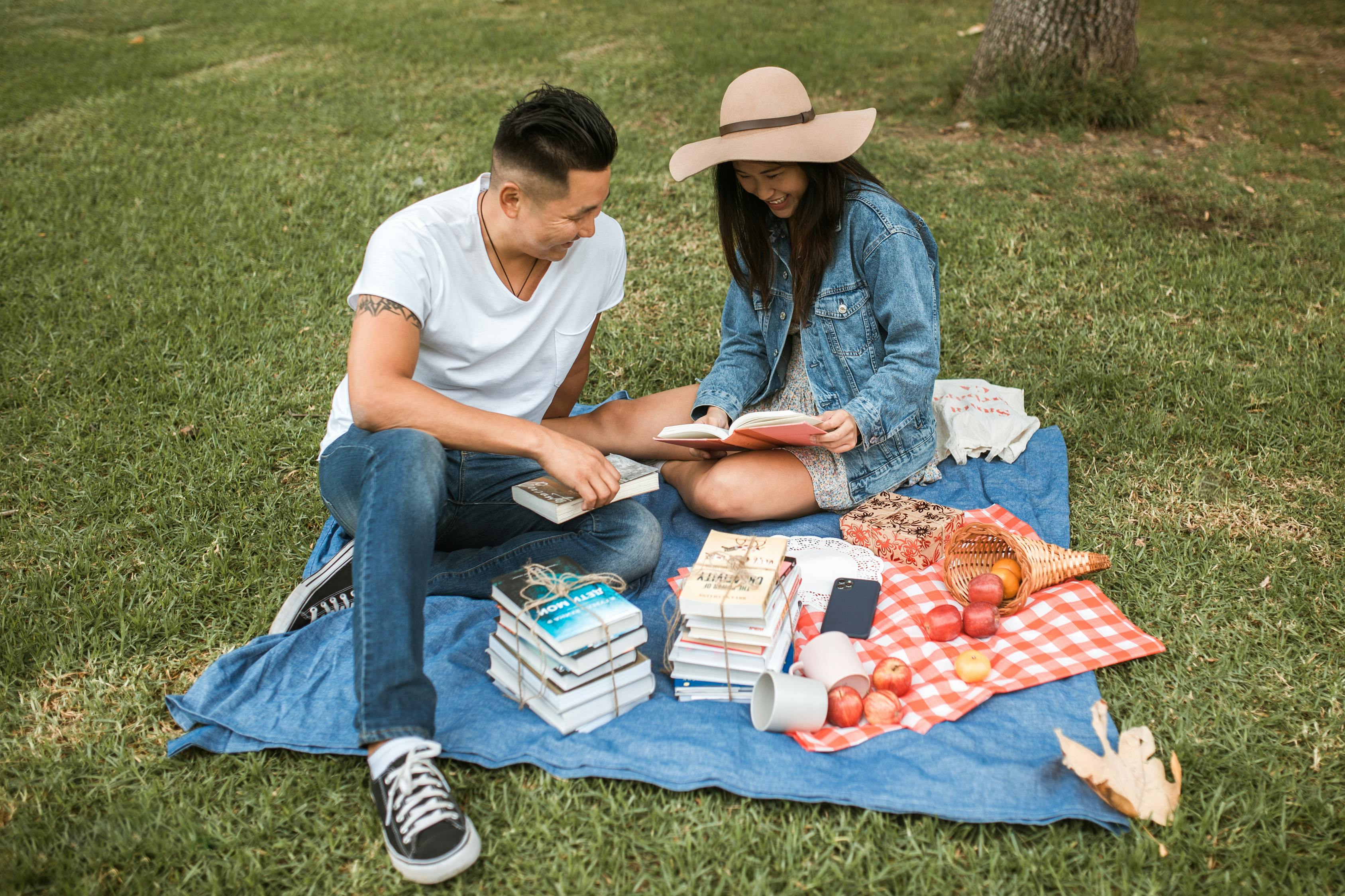 Woman In White Shirt And Blue Denim Jeans Sitting On Grass Field Beside