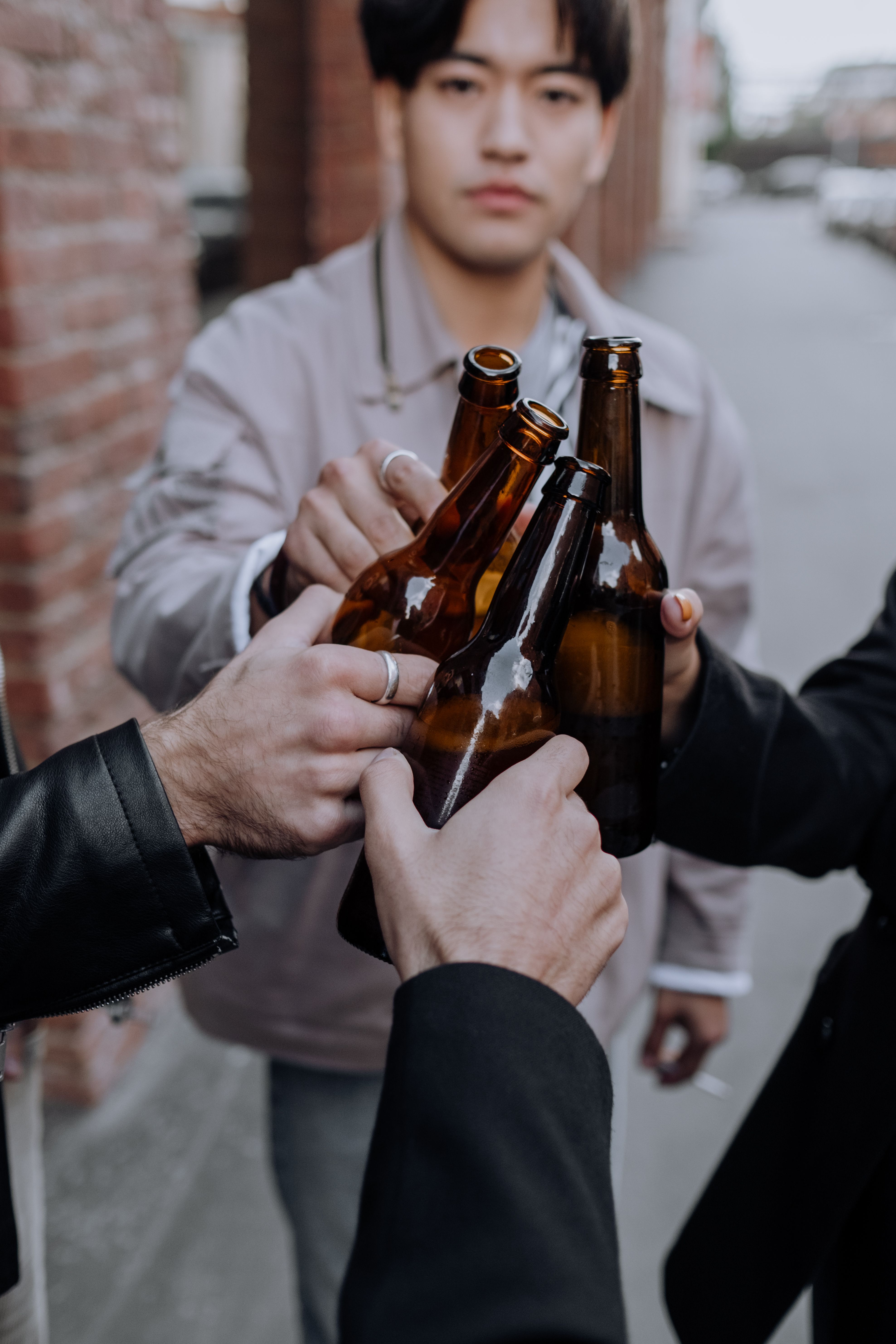 Person Holding Brown Glass Bottles · Free Stock Photo
