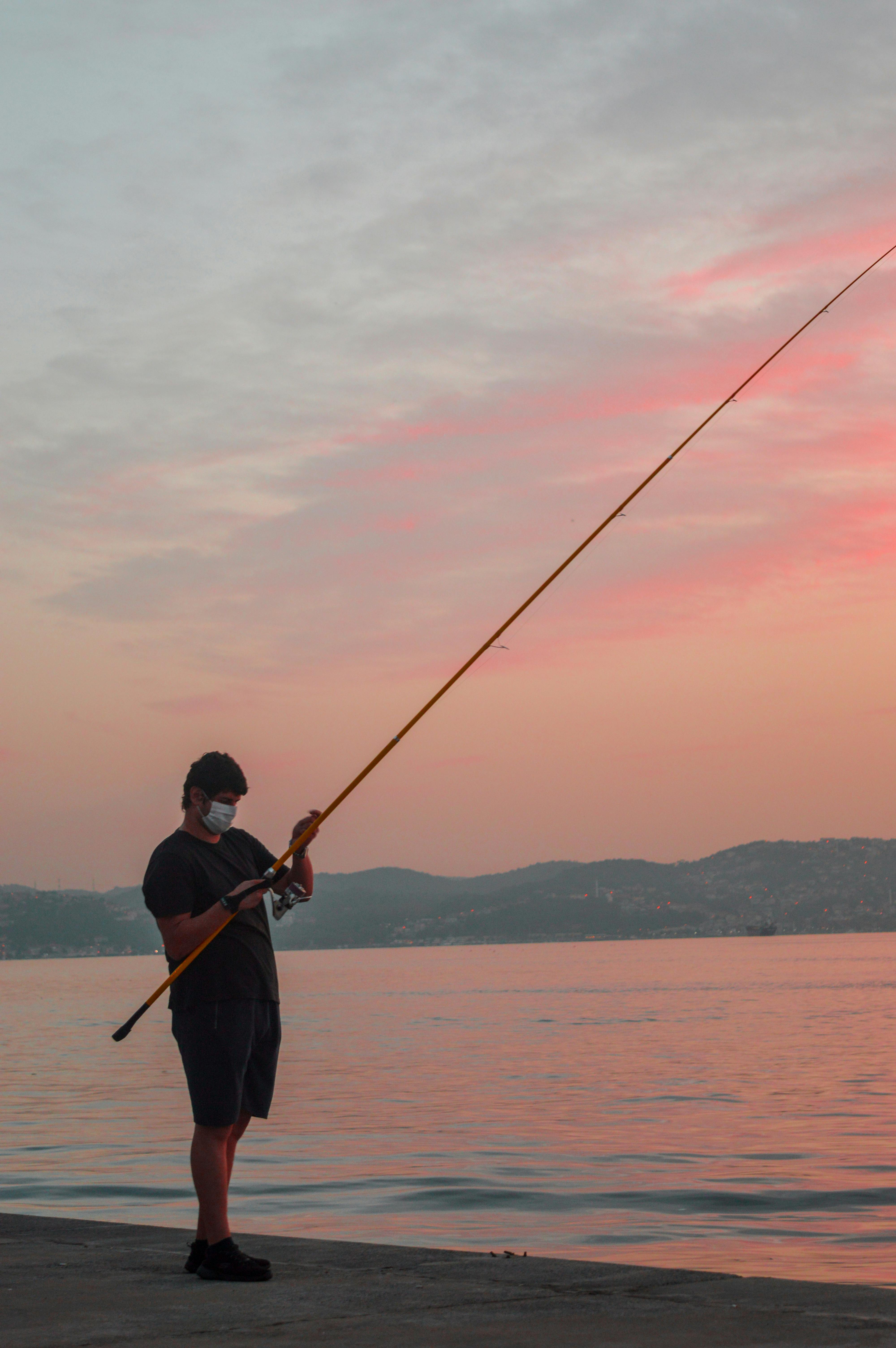 A Silhouette of Men Fishing on a Shore · Free Stock Photo