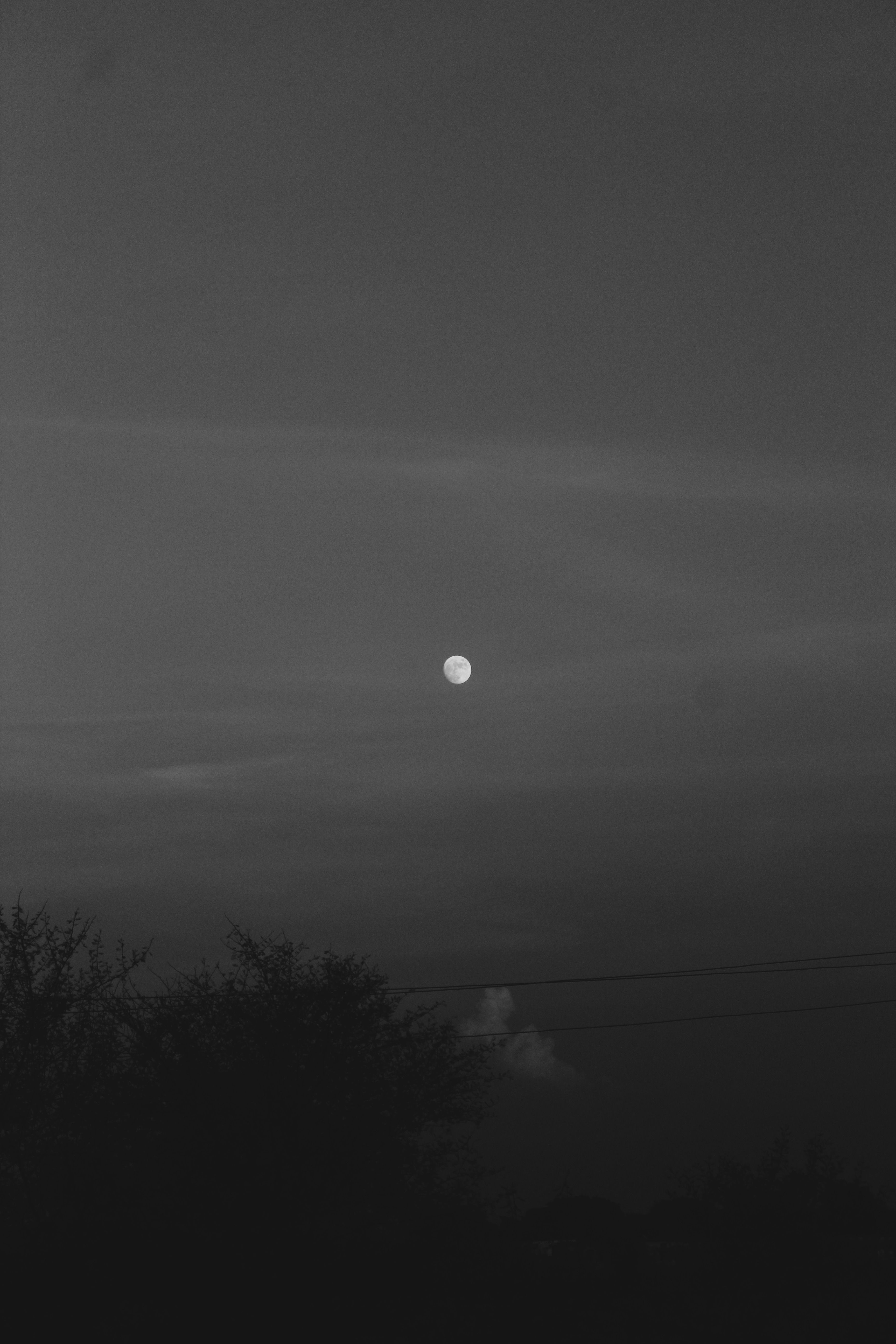 Grayscale Photo of a Full Moon from a Distance · Free Stock Photo