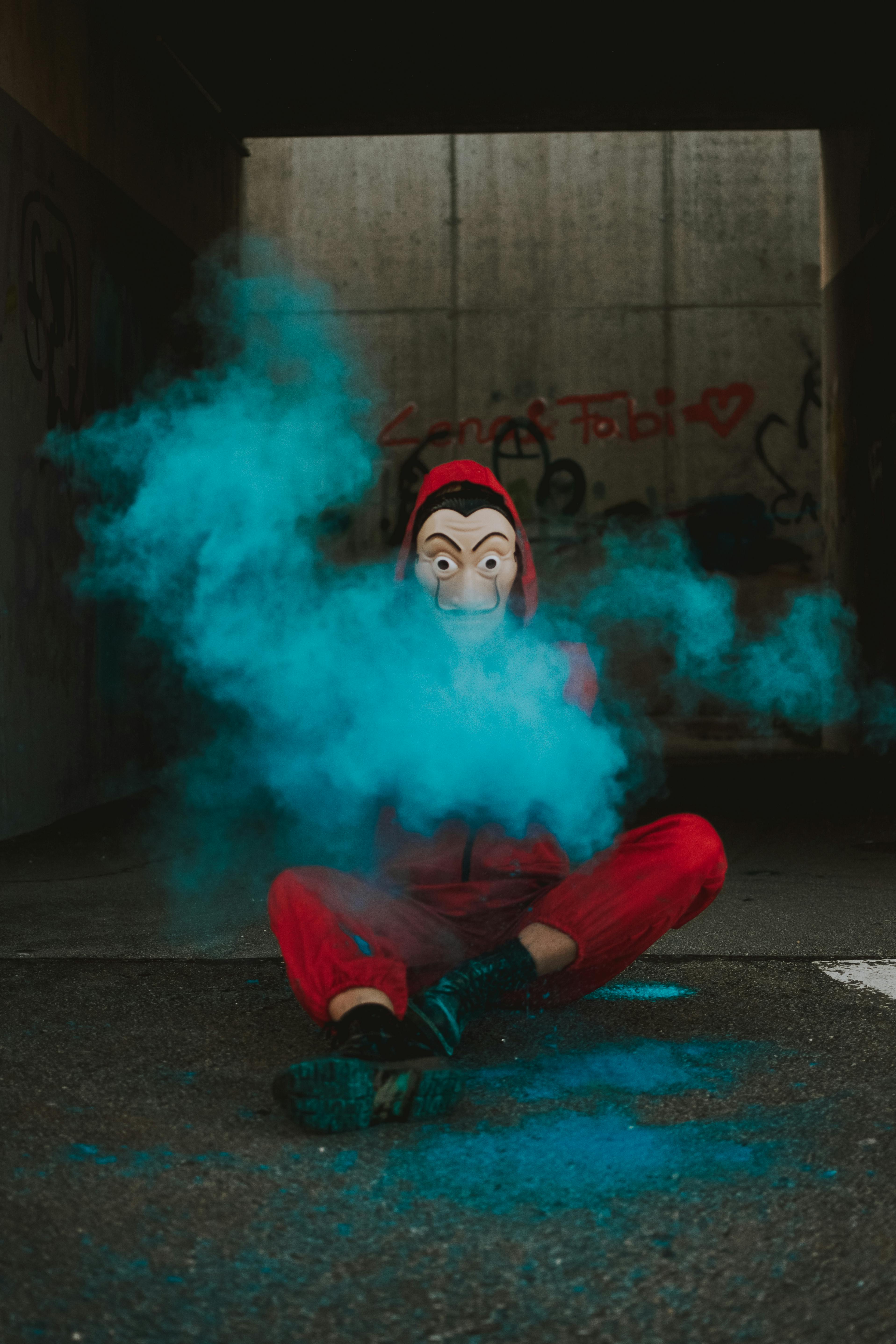 Person in mask and overall spreading color powder · Free Stock Photo