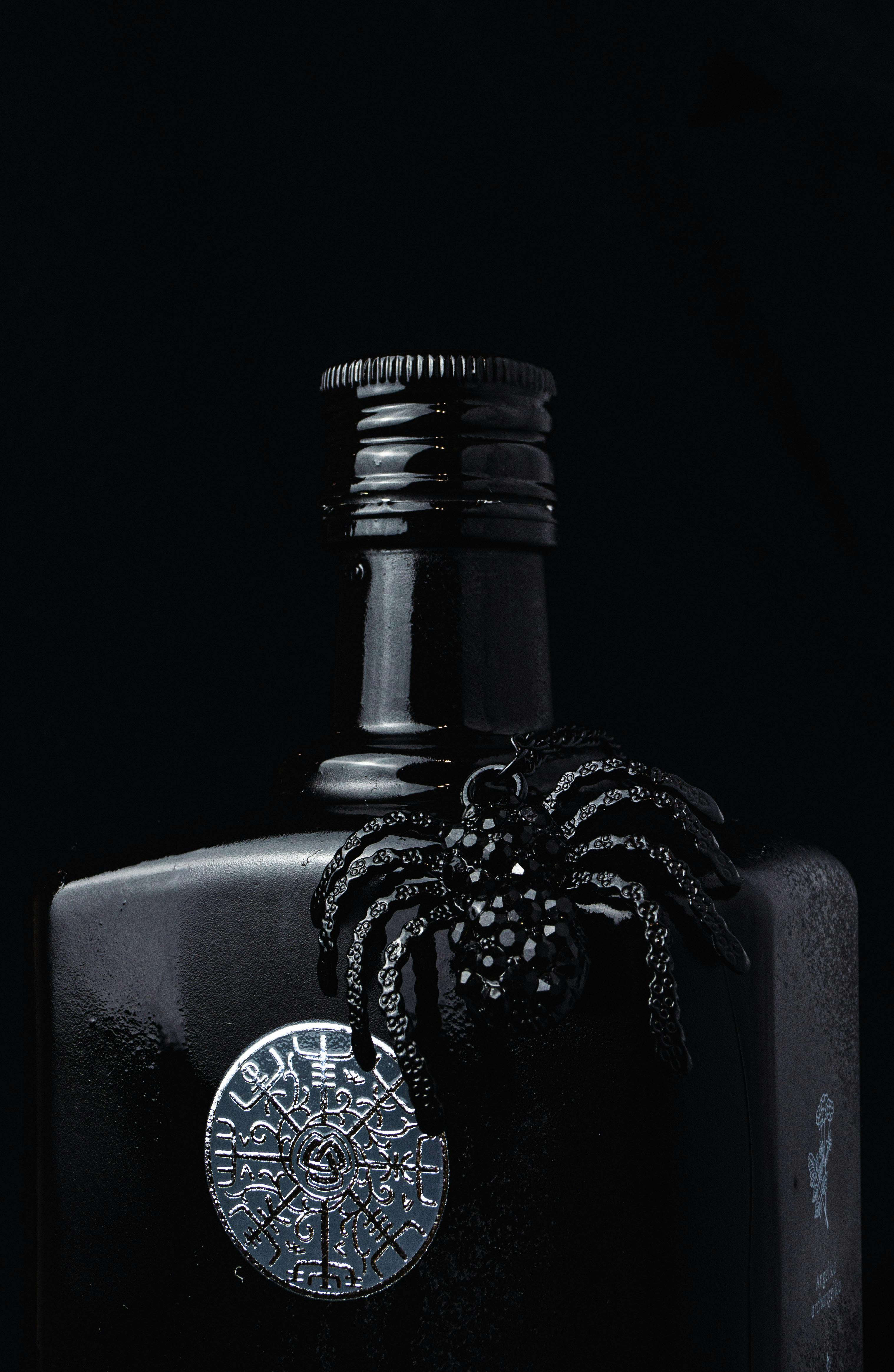 Black Alcohol Bottle with Spider Charm Atta · Free Stock Photo