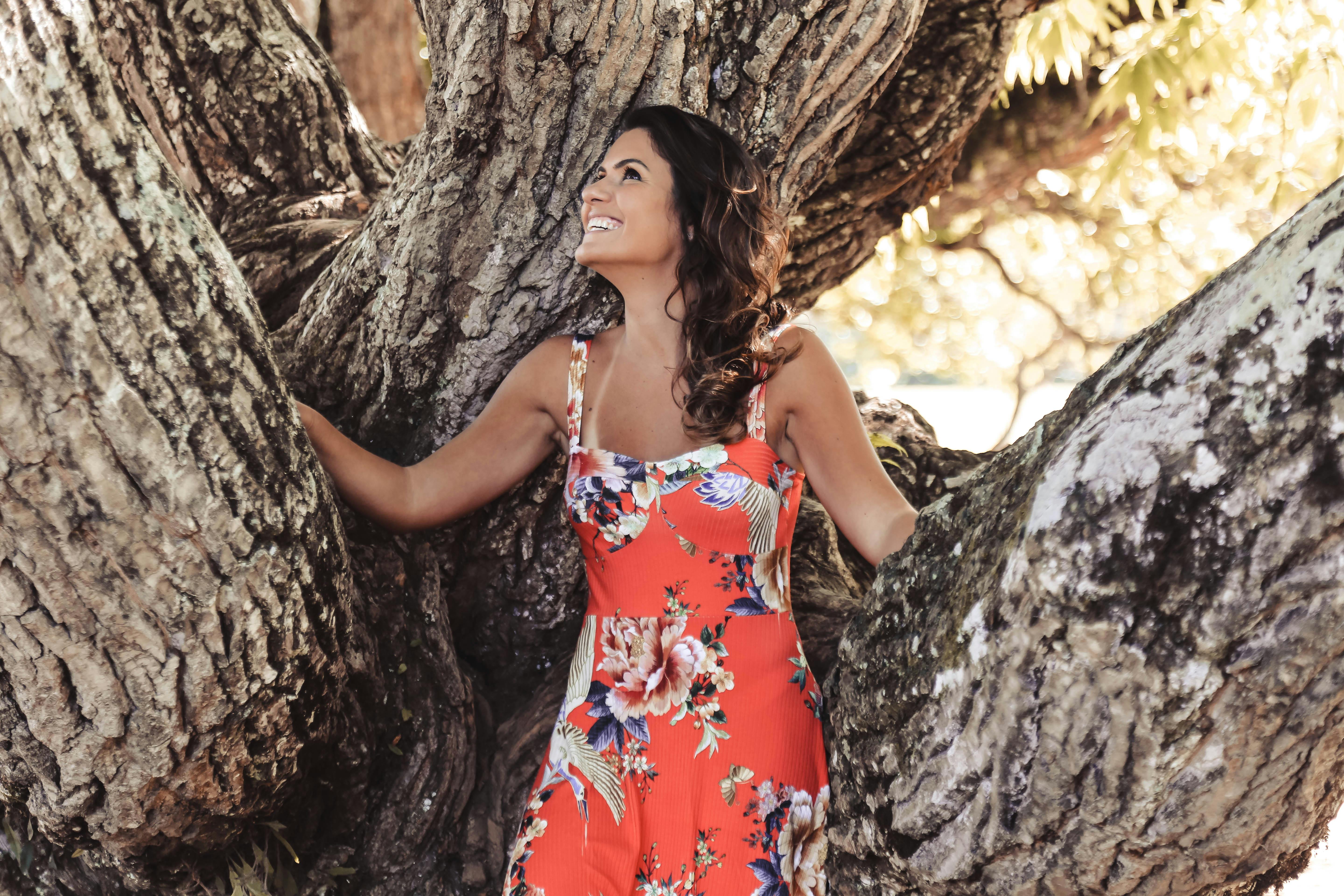 Woman Standing Between Huge Tree Branches and Smiling · Free Stock Photo