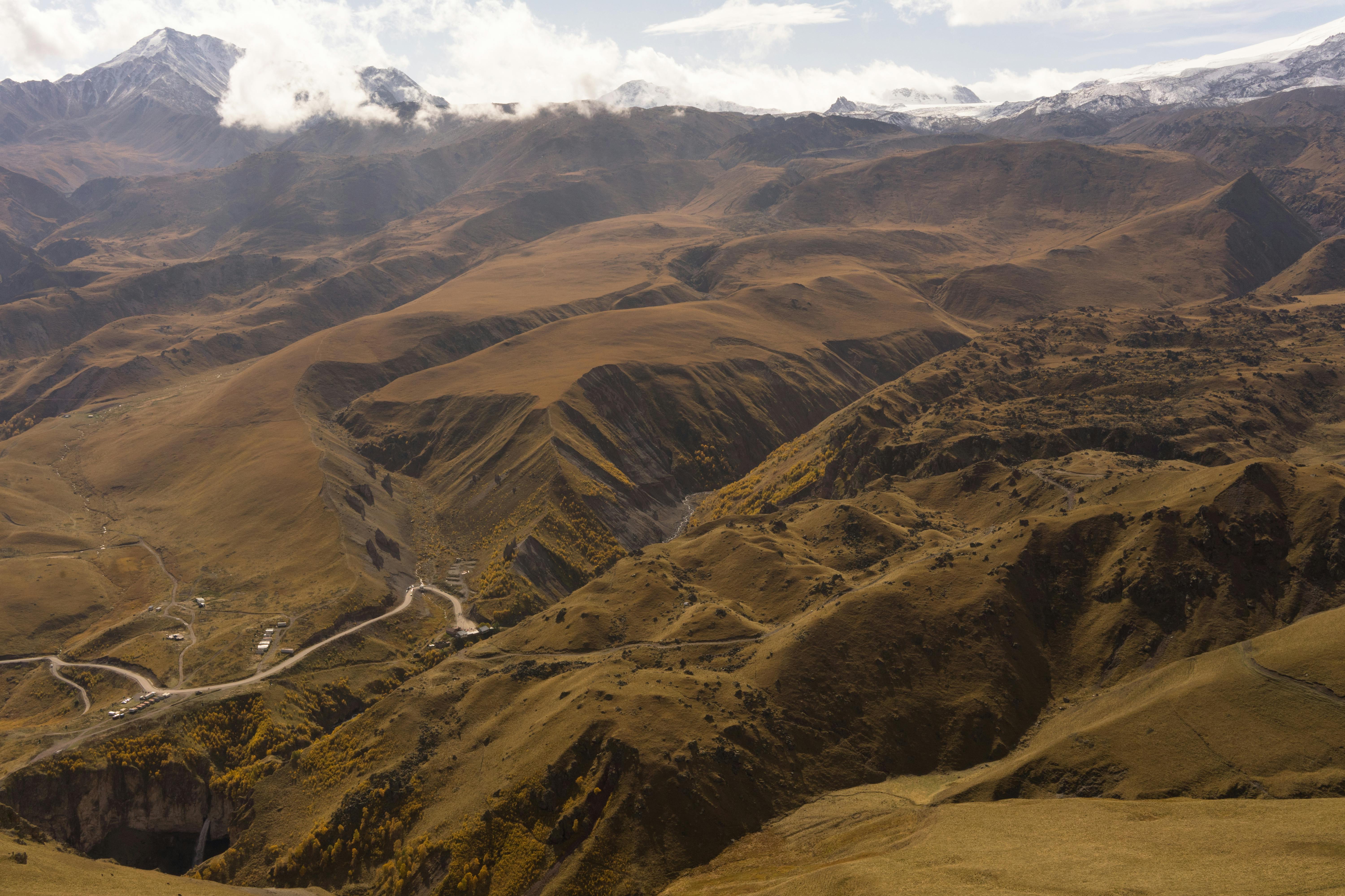 Mountainous terrain under cloudy sky · Free Stock Photo