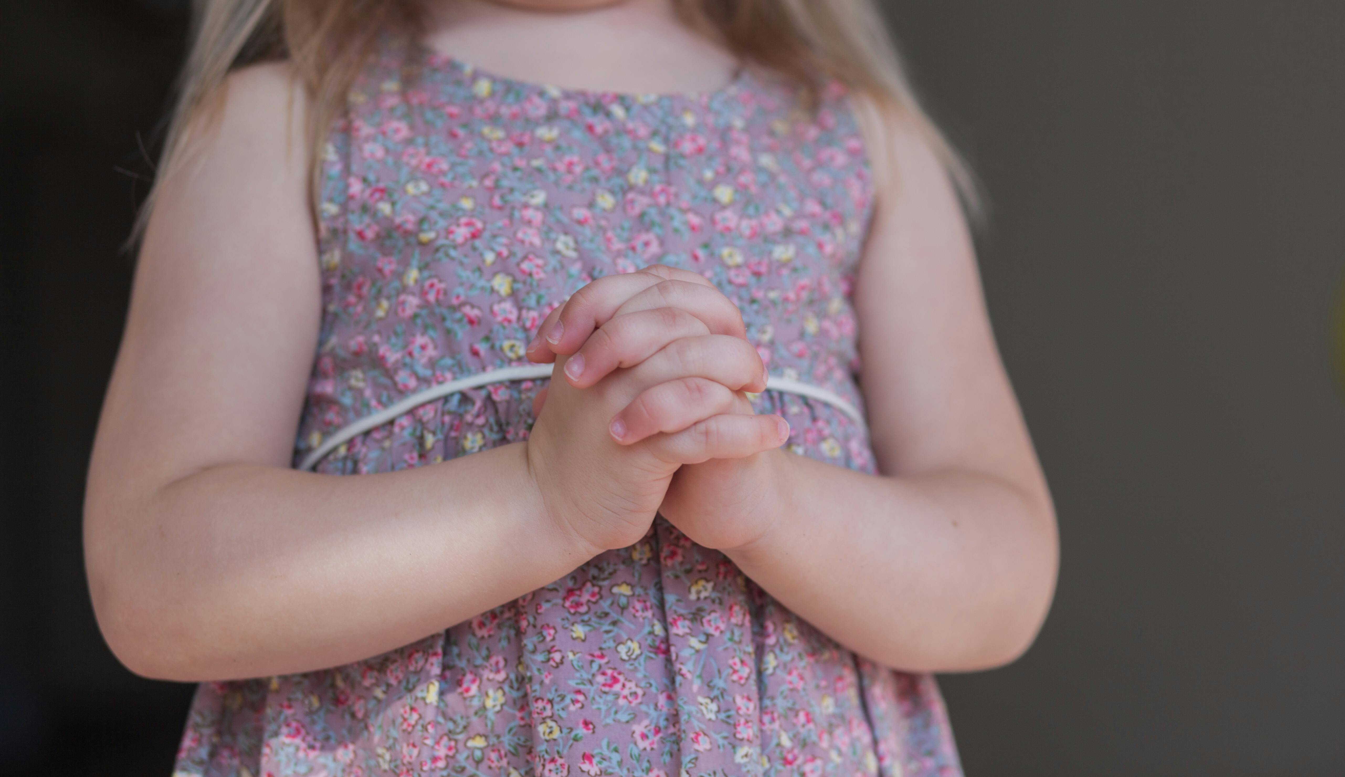 Cute unrecognizable girl with prayer hands on gray background · Free ...