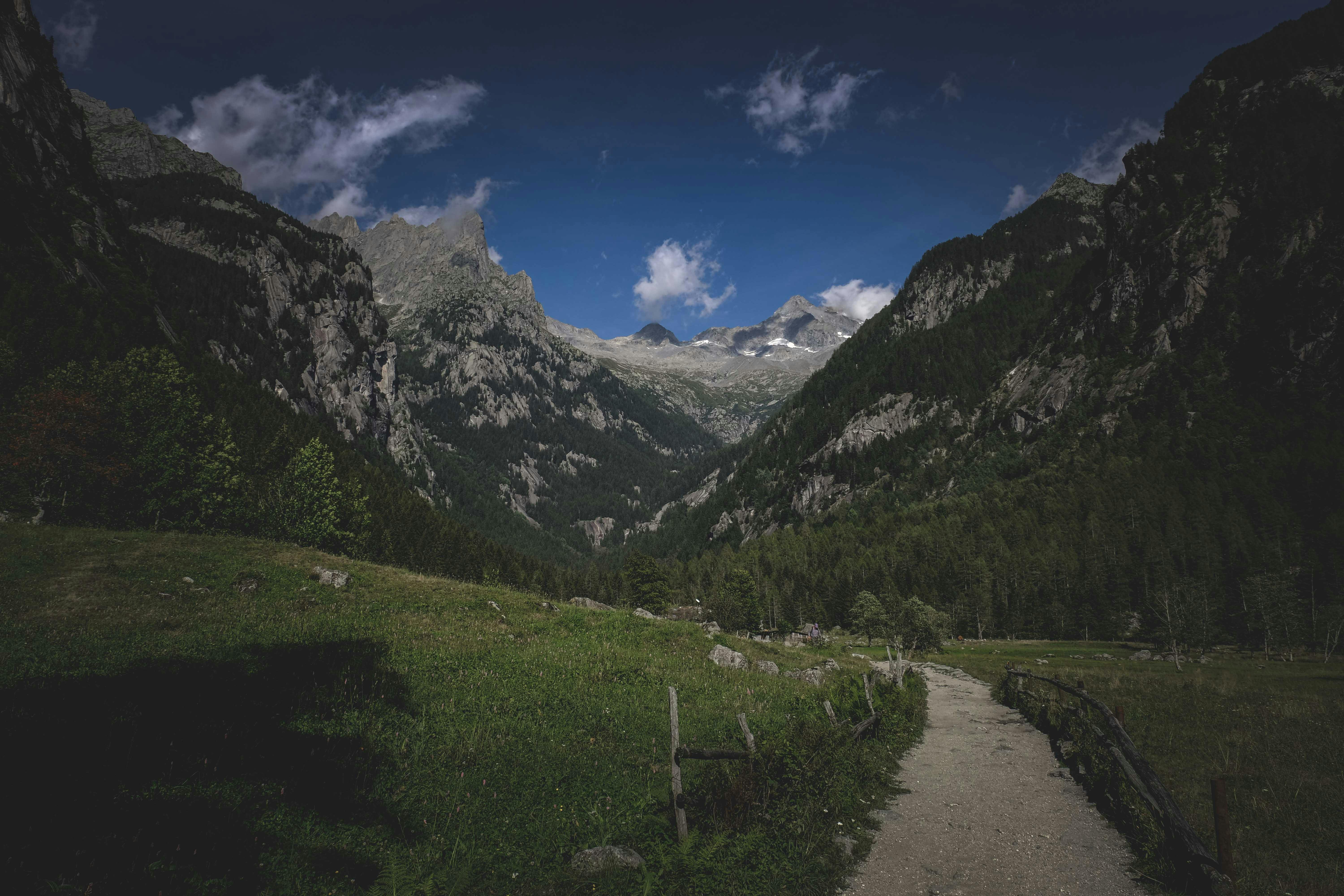 Narrow path through grassy mountainous valley · Free Stock Photo