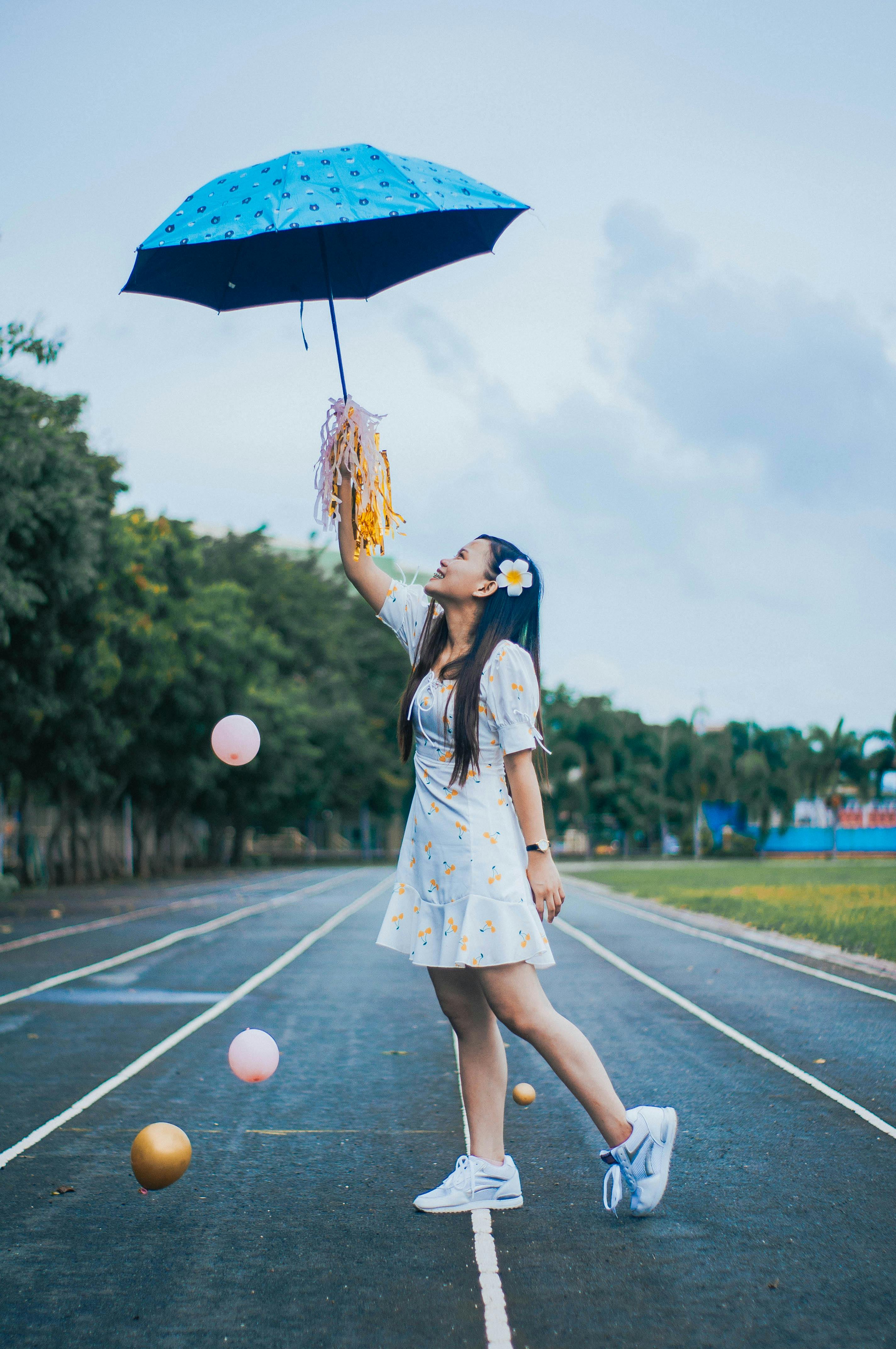 Asian woman with umbrella on road · Free Stock Photo