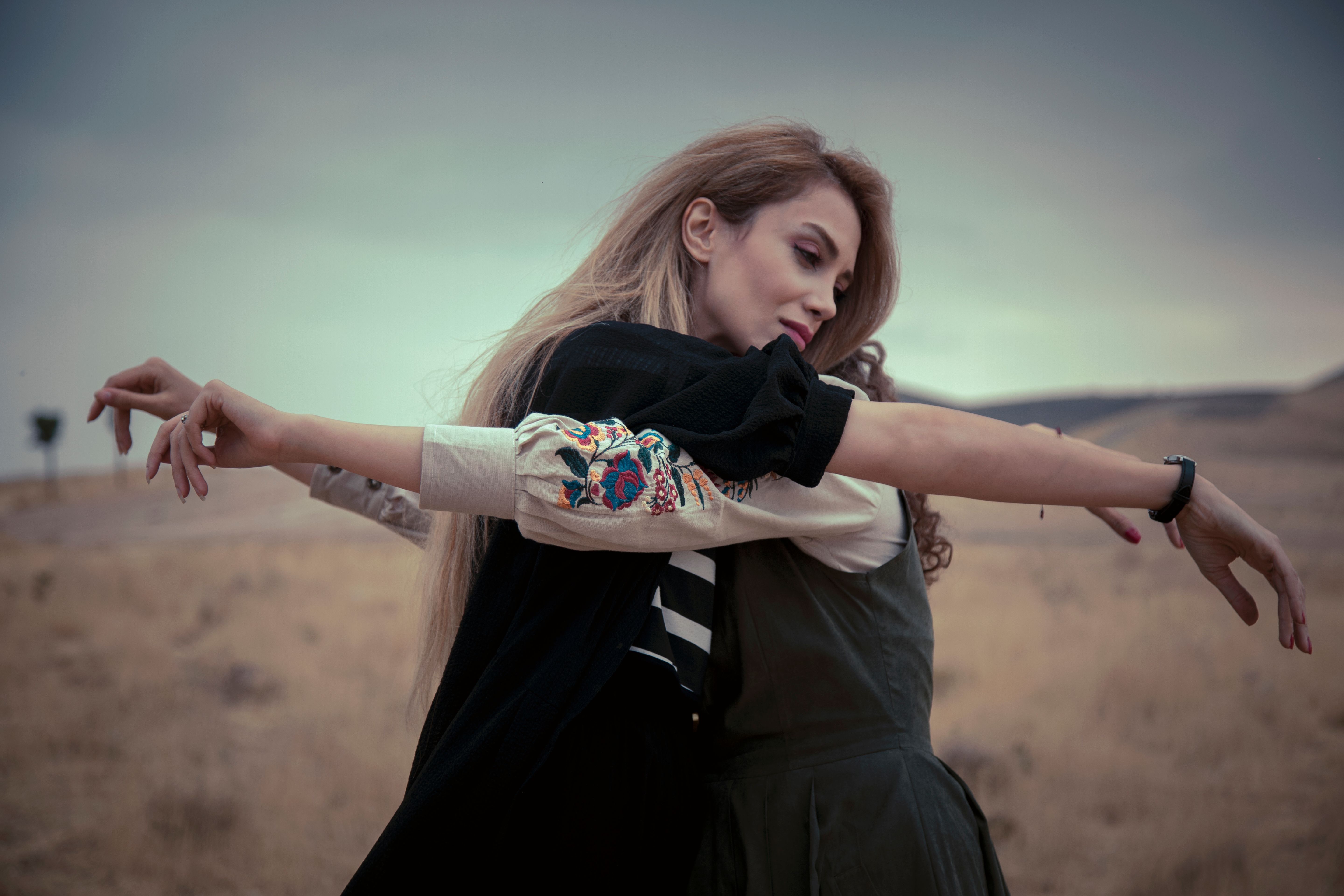 Women embracing with raised arms · Free Stock Photo