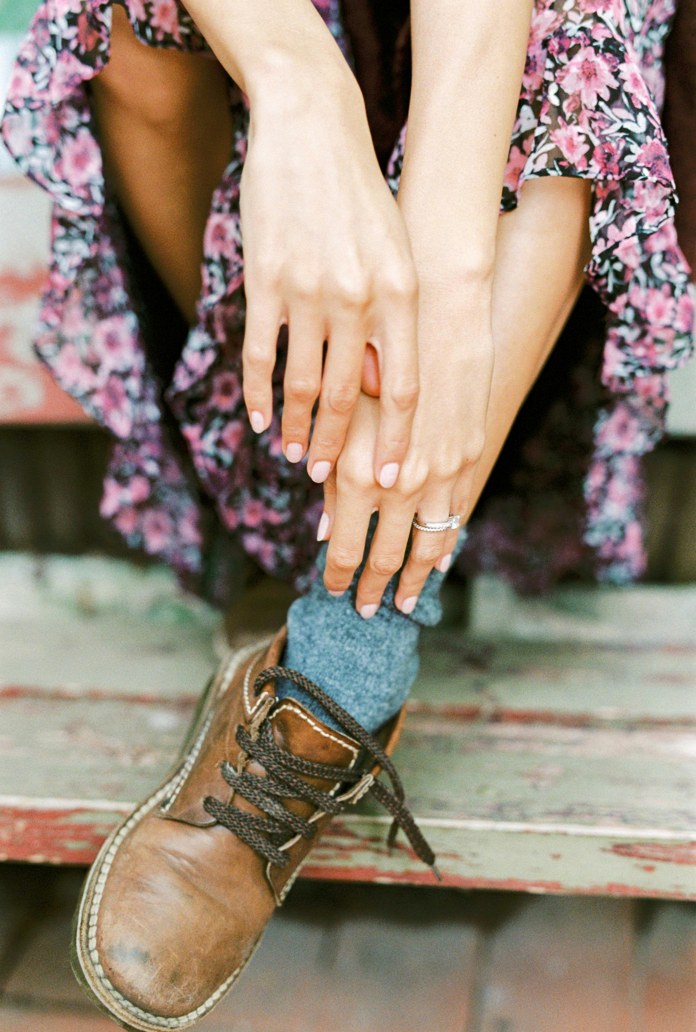 Photograph of a Person's Hands Near Her Brown Boot · Free Stock Photo