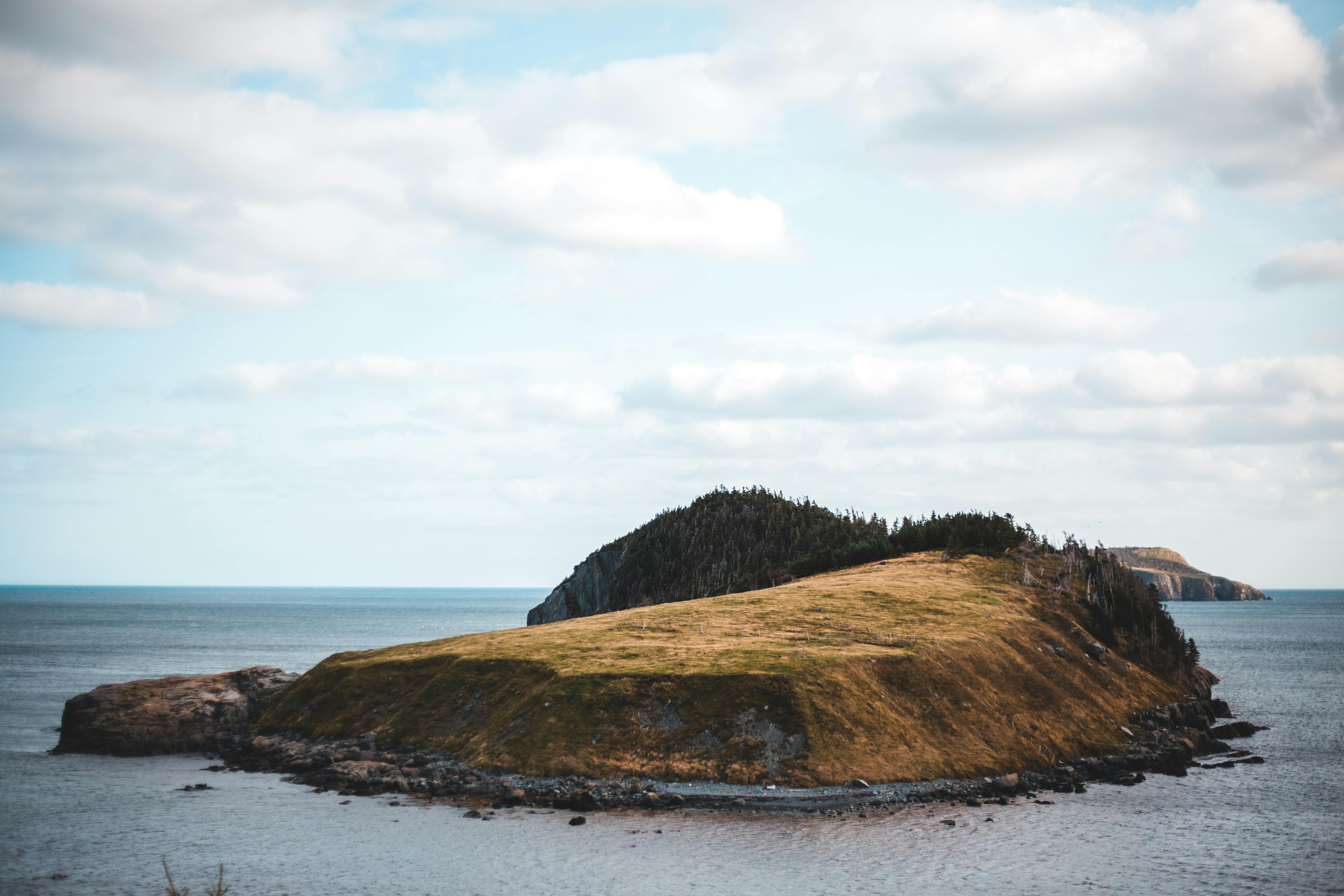 Green mountain near blue ocean in summertime · Free Stock Photo