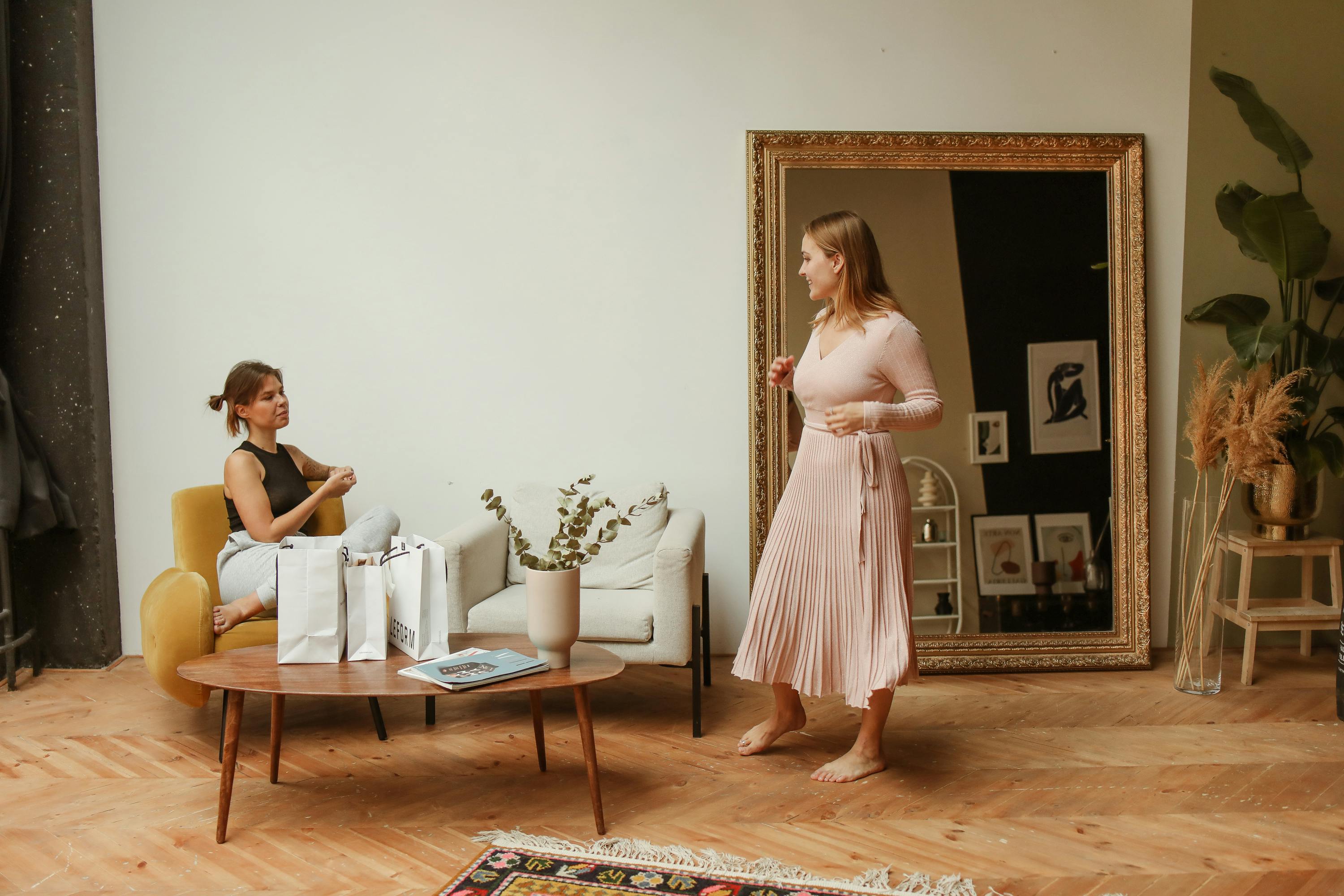 Women Trying on Clothes in a Living Room · Free Stock Photo