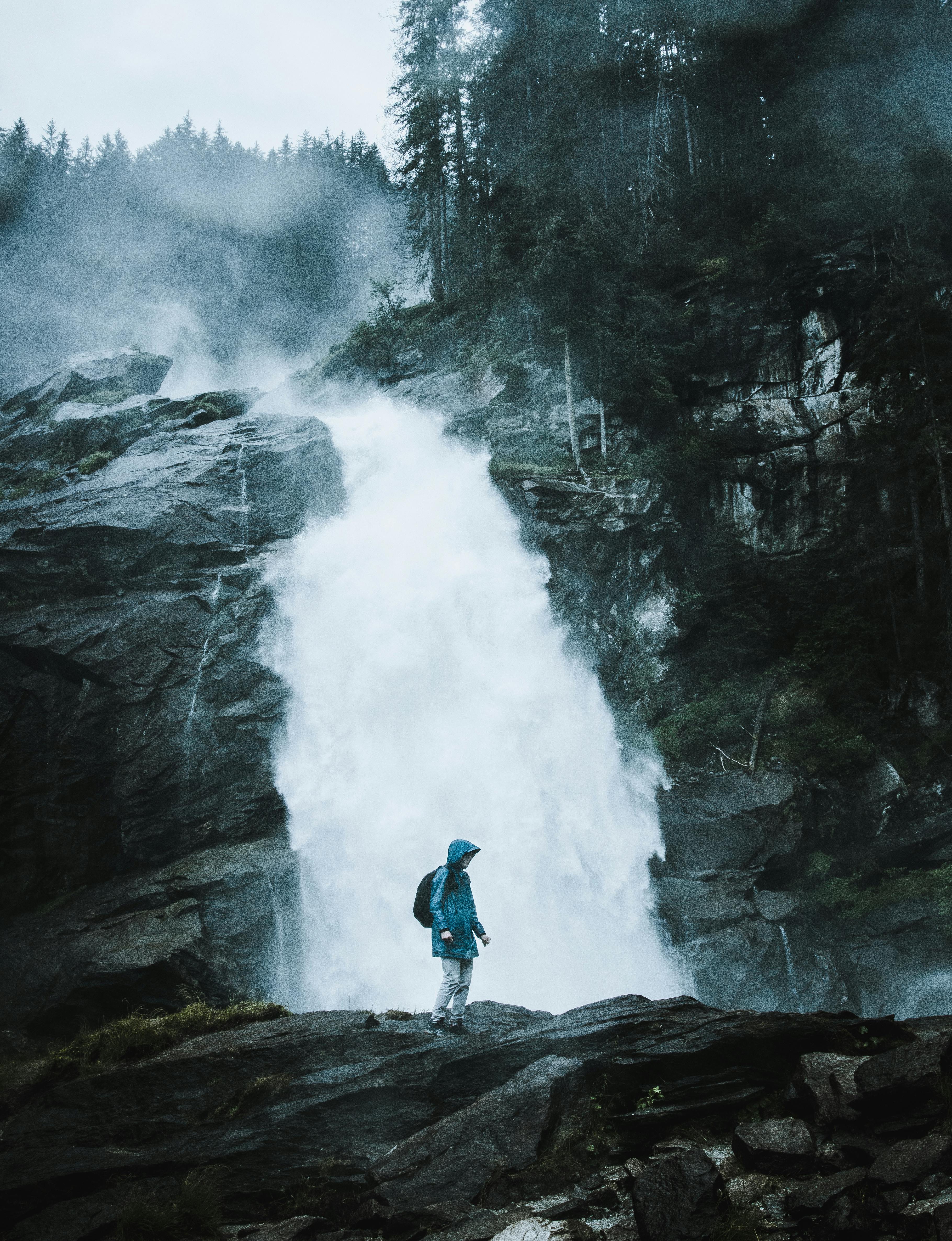 Person Sitting on Rock Near Waterfalls · Free Stock Photo