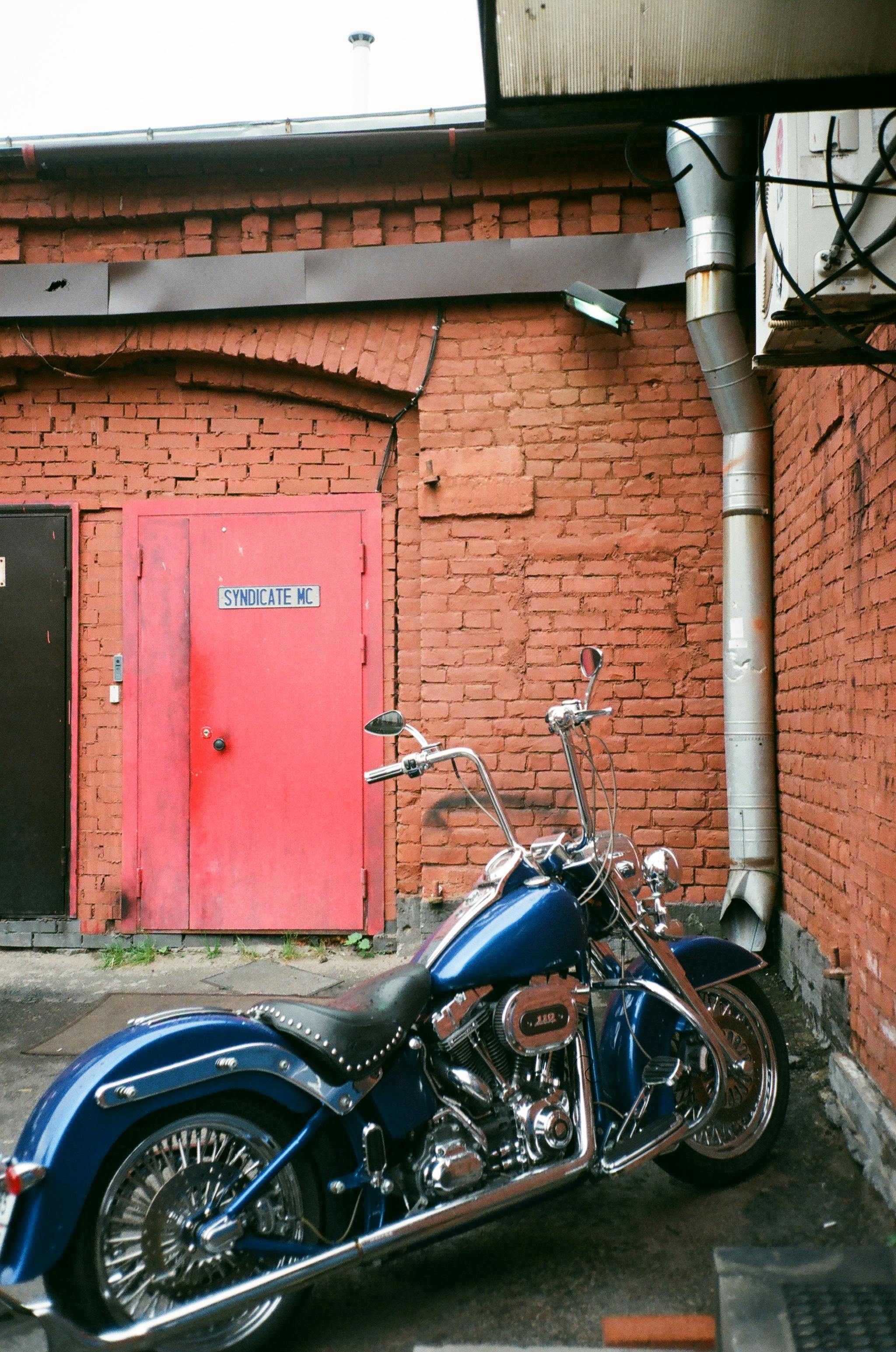 Retro motorbike parked near old garage · Free Stock Photo