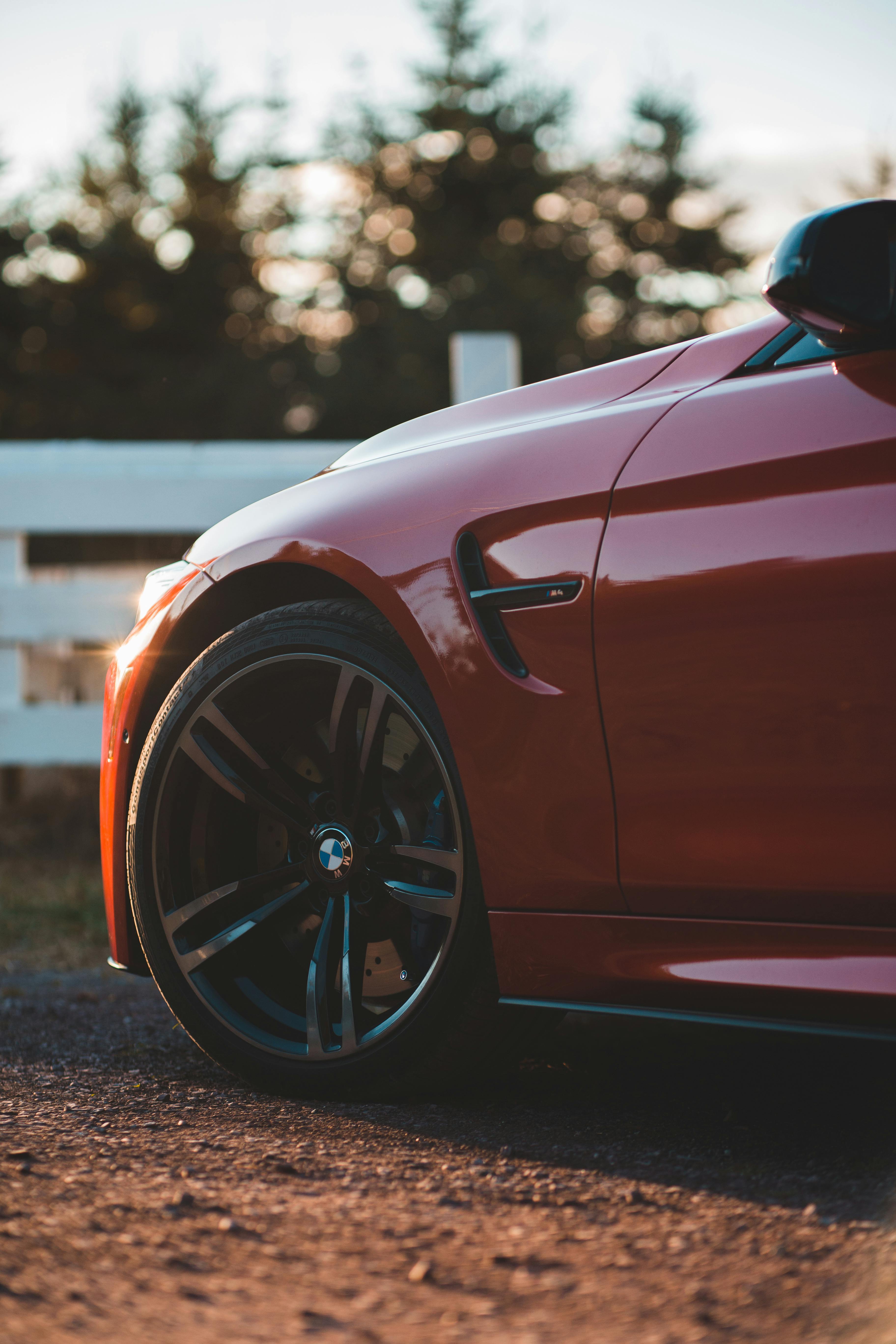 Wheel of stylish red car parked on rural road in sunlight · Free Stock ...