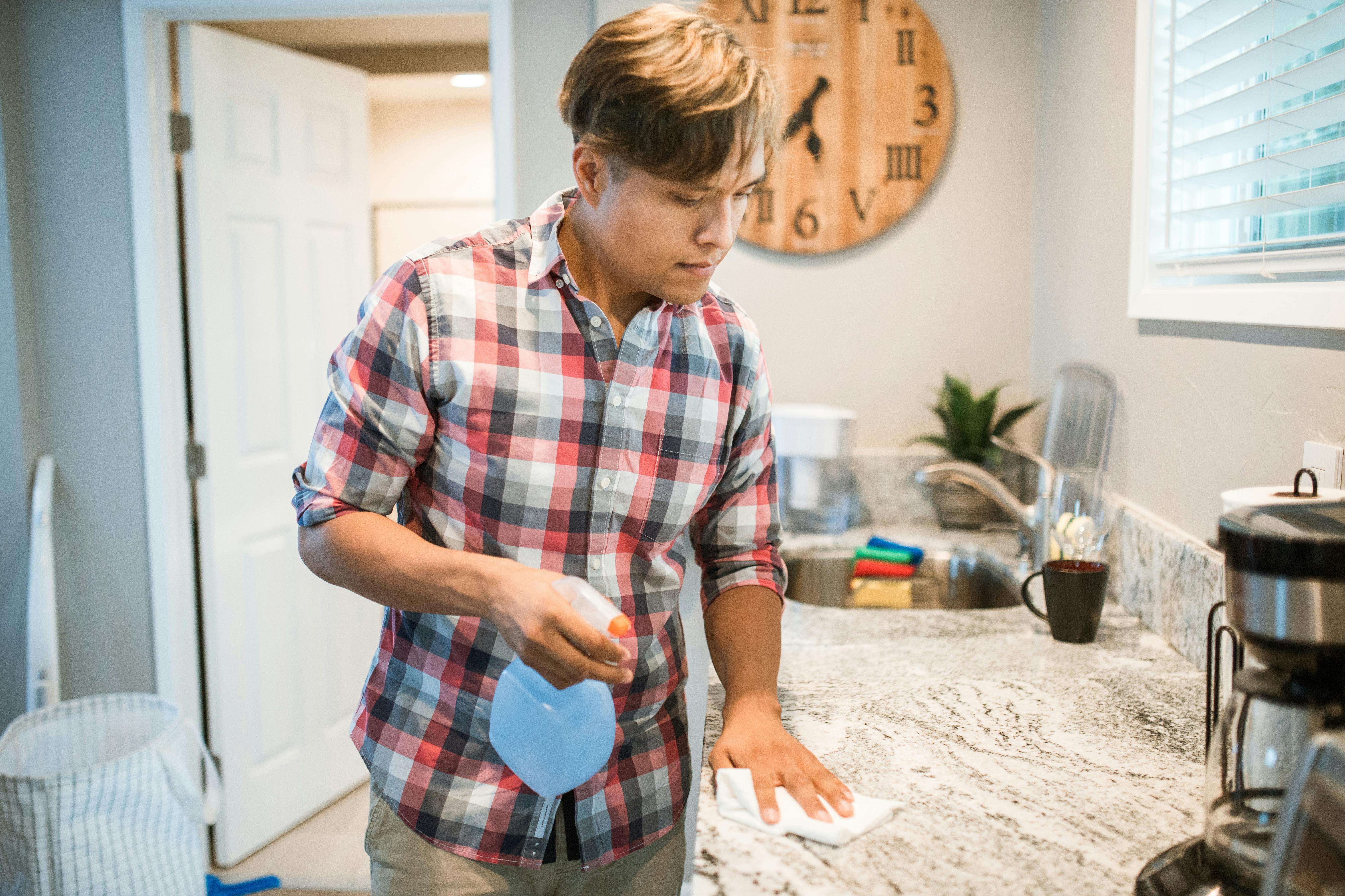 A Man Wiping a Kitchen Counter · Free Stock Photo