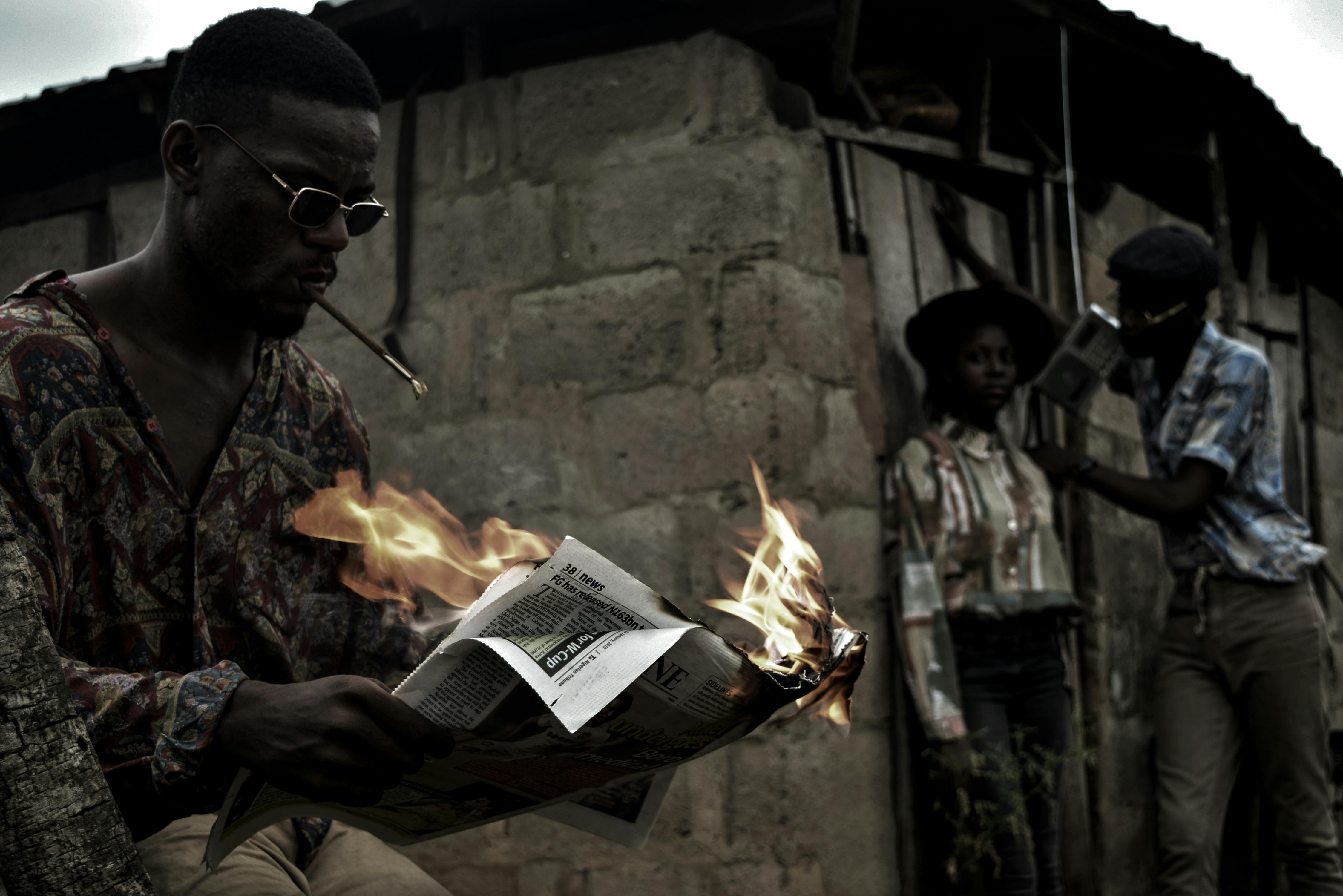 Man Holding Burning Newspaper · Free Stock Photo