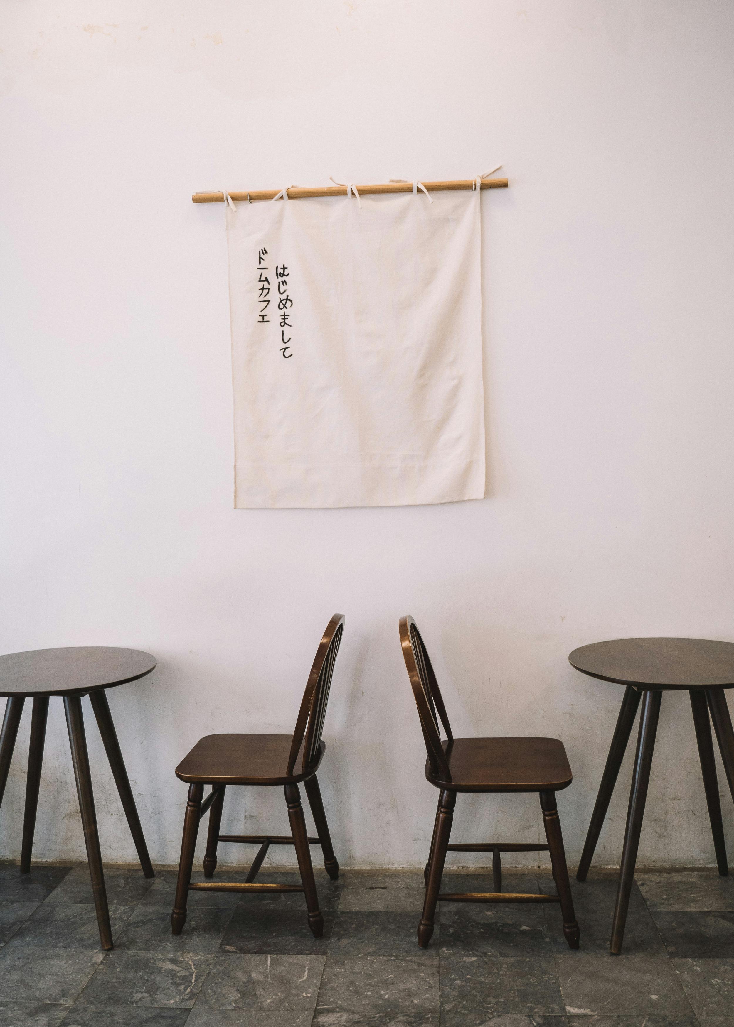 Wooden Table and Chairs and a Fabric Sign · Free Stock Photo
