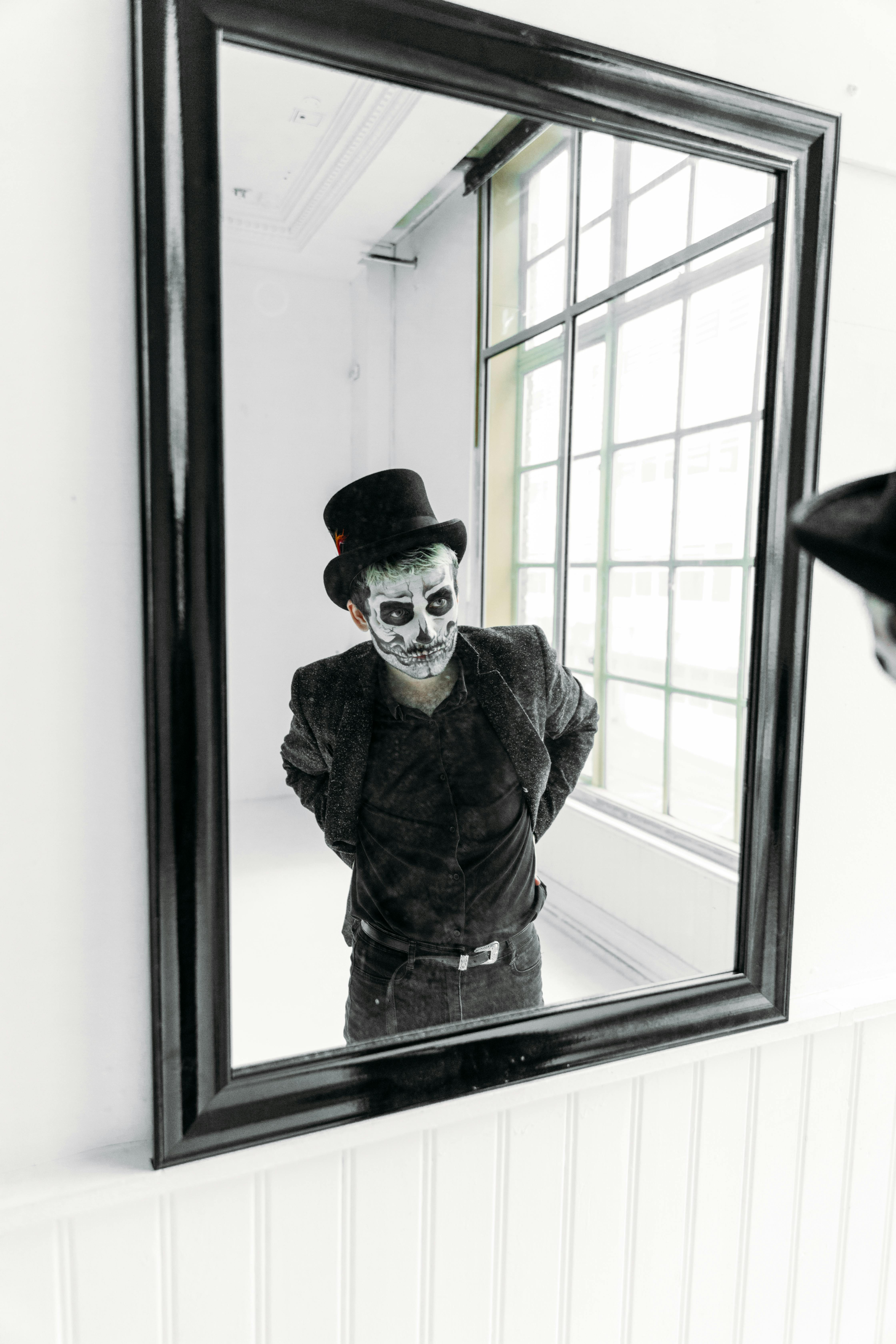 Reflection Of A Man With Scary Face Paint On A Mirror · Free Stock Photo