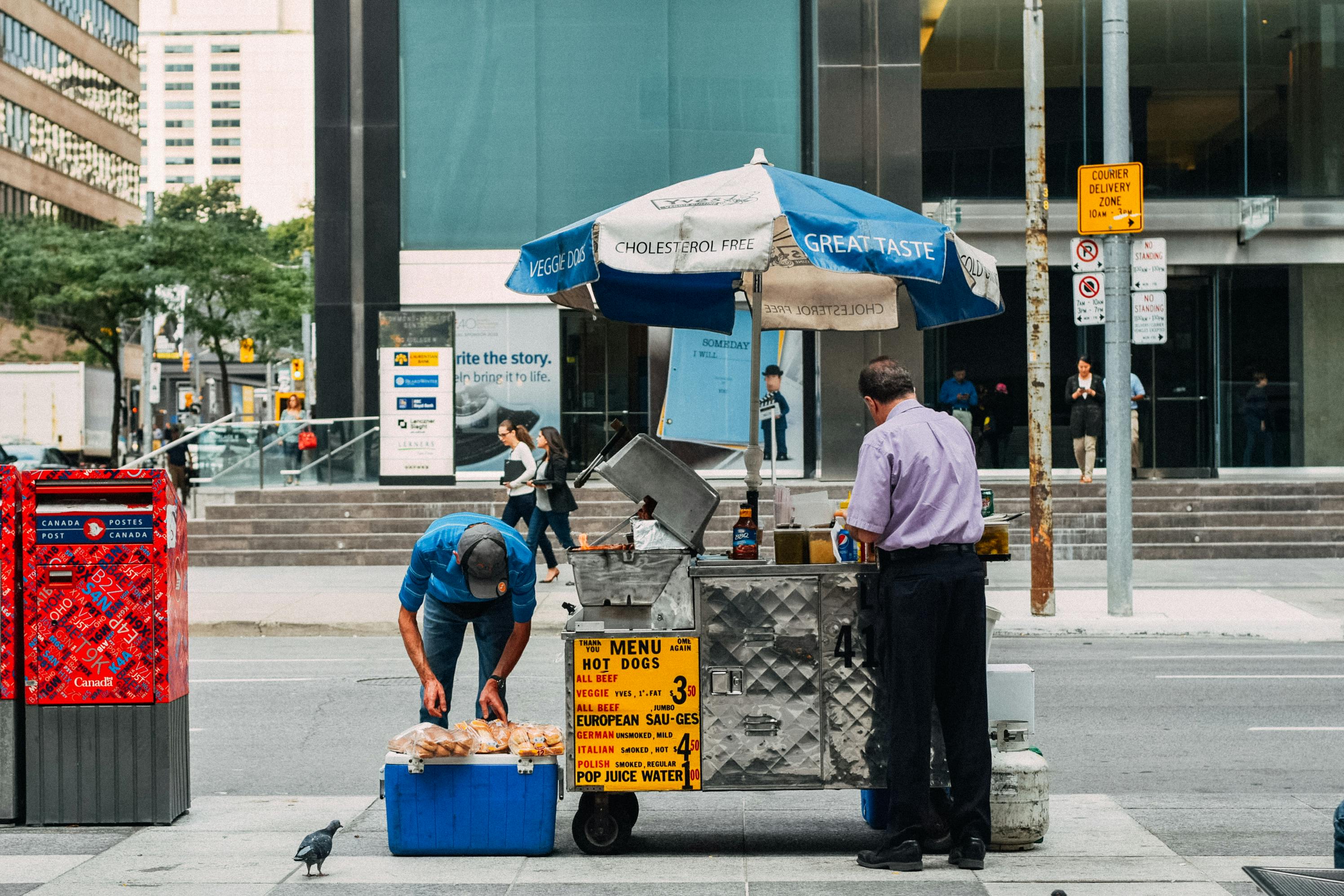 Man working behind street food cart · Free Stock Photo