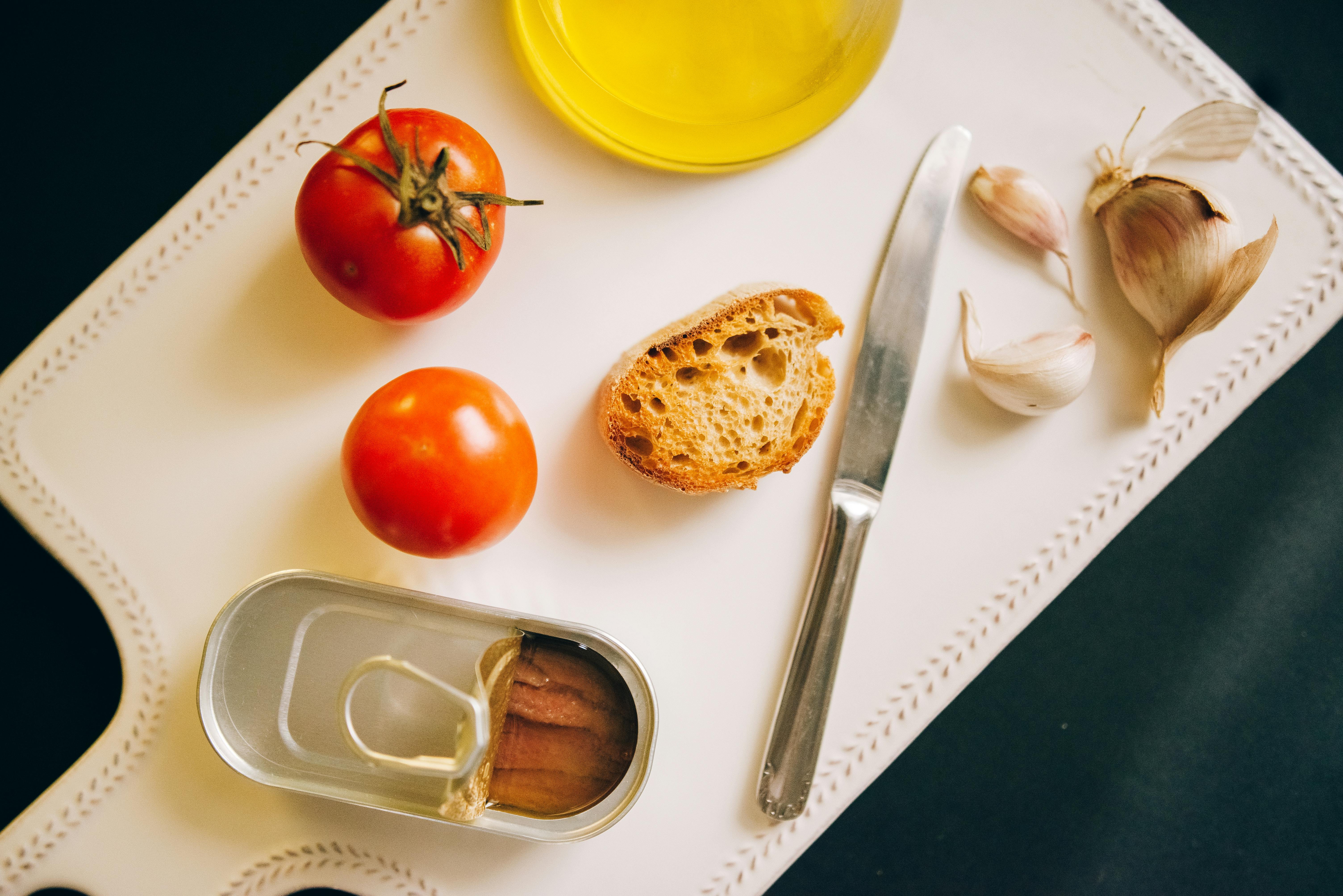 Little Piece of Bread on a Cutting Board Next to Tomatoes a Can of ...