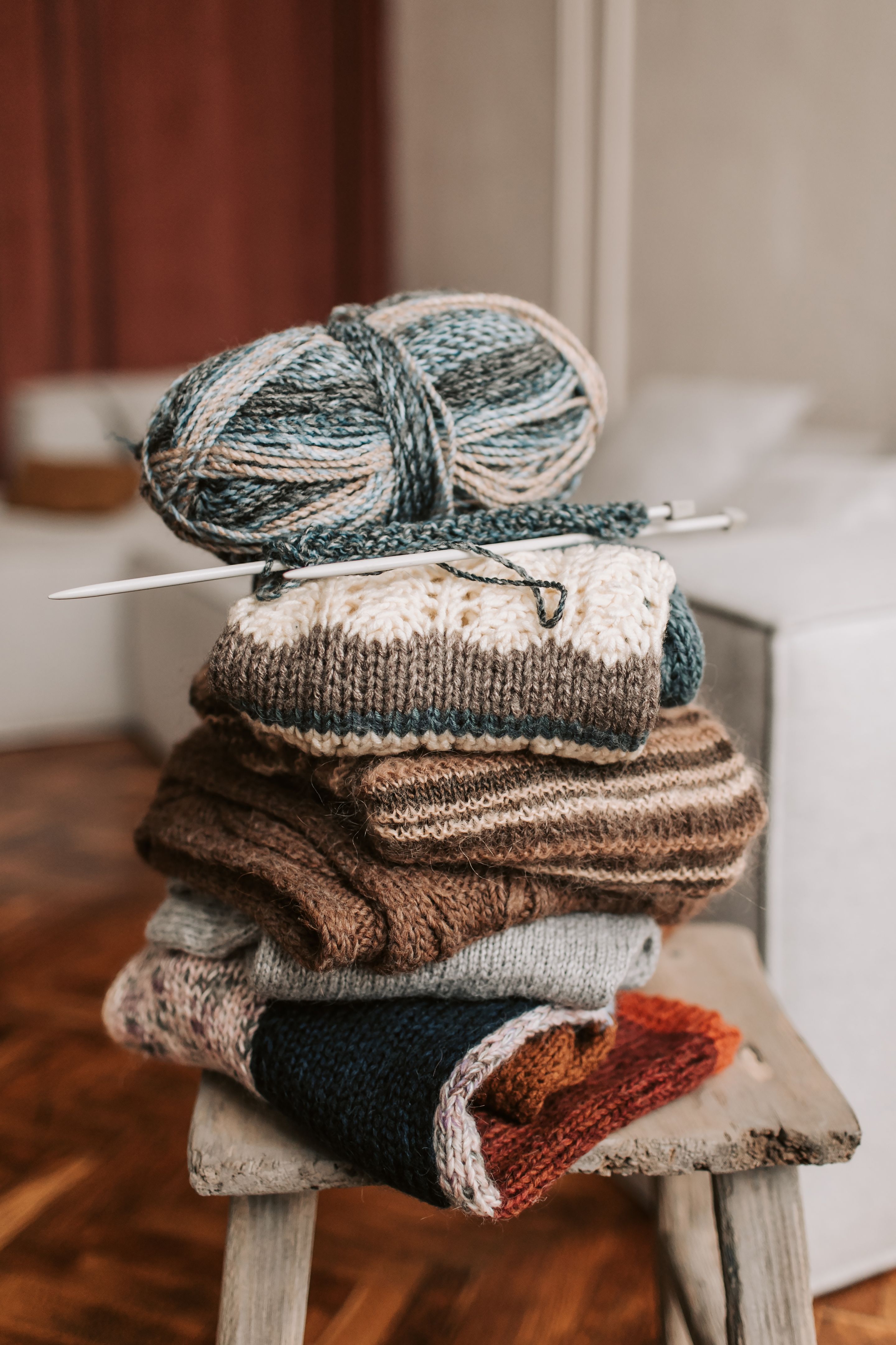 Ball of Yarn and a Knitting Needles on a Stack of Handmade Scarves ...