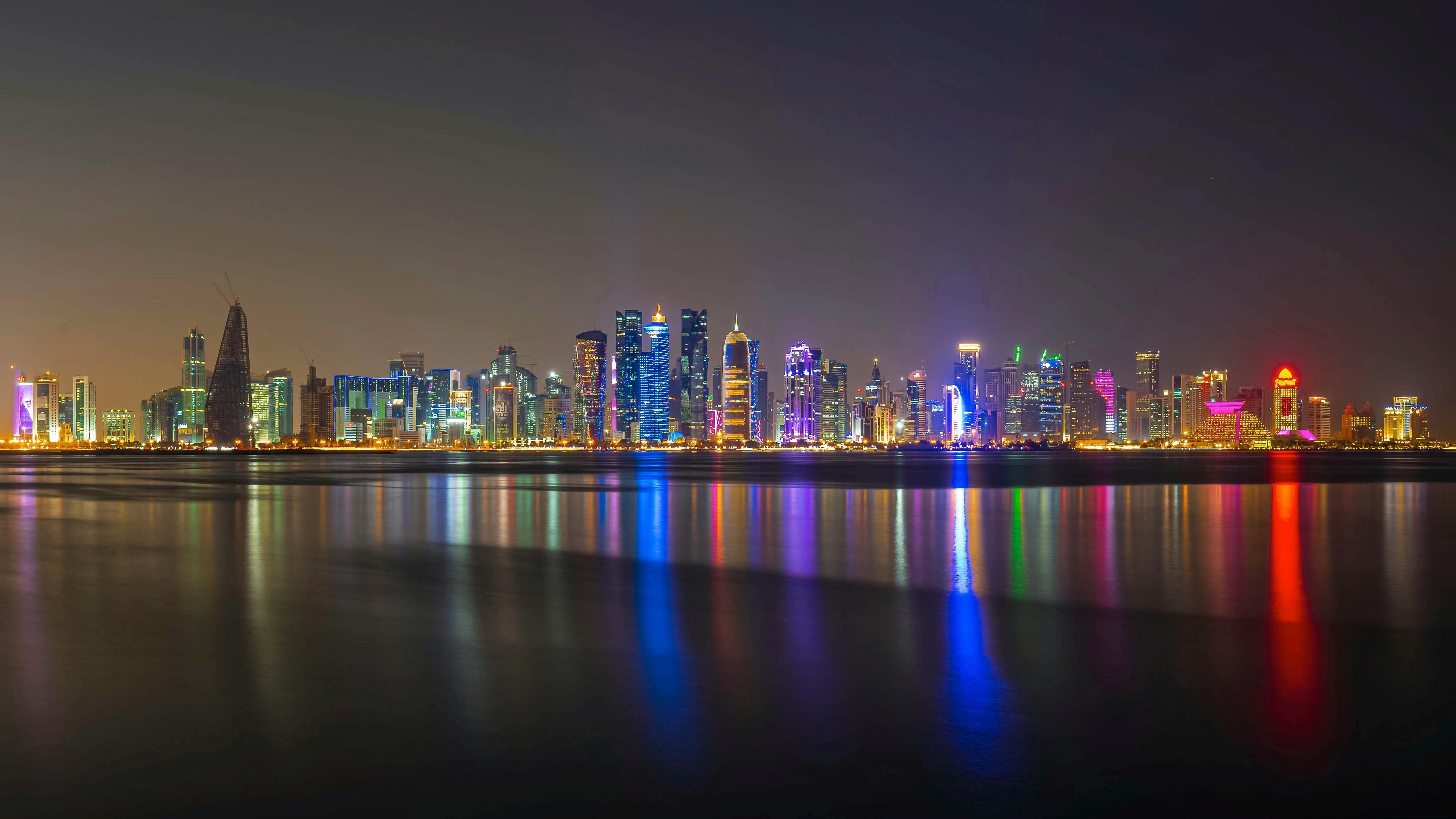 Modern megapolis reflecting in sea at night time · Free Stock Photo