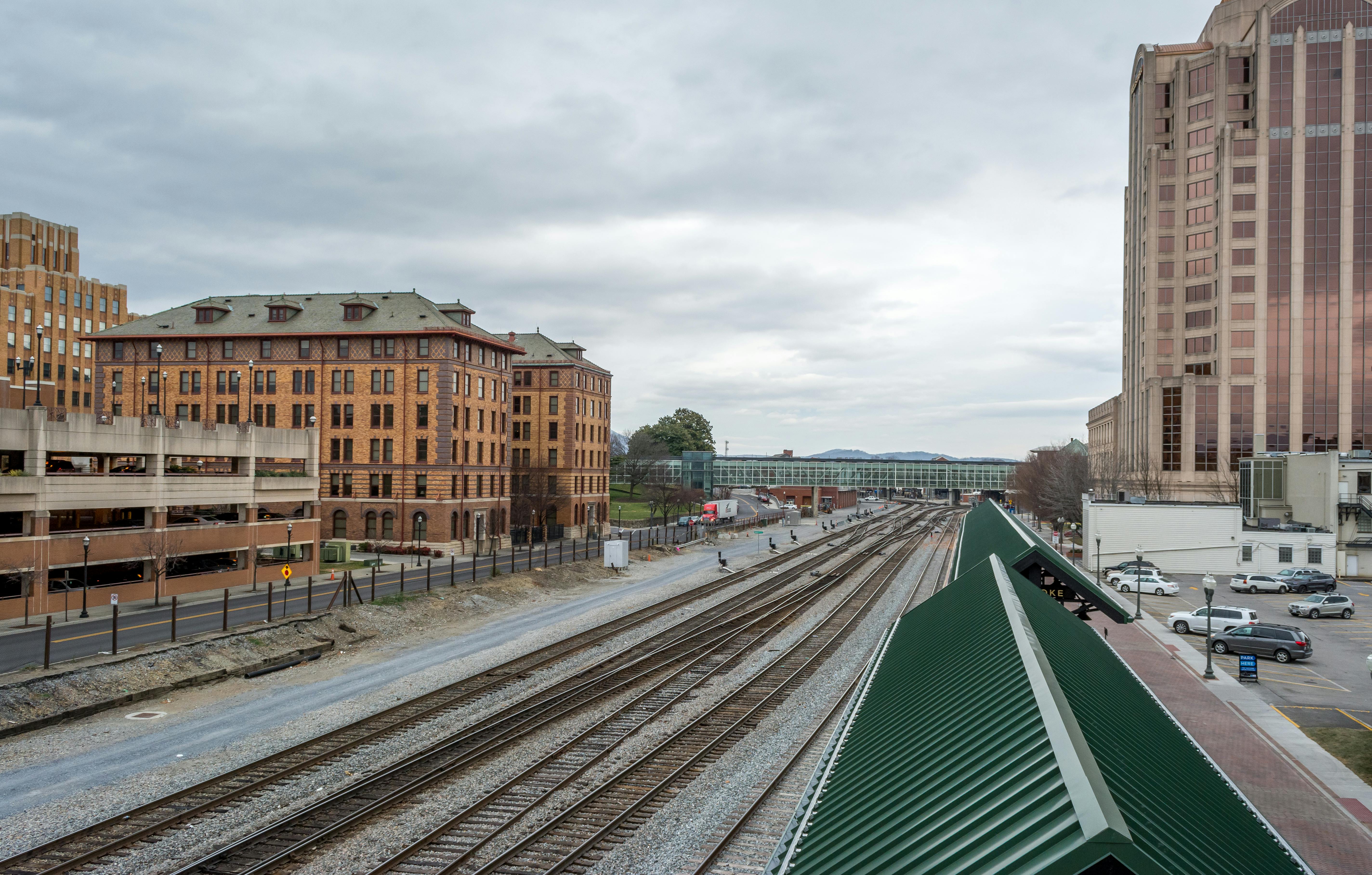Brown and Green Concrete Building Near Train Rail · Free Stock Photo