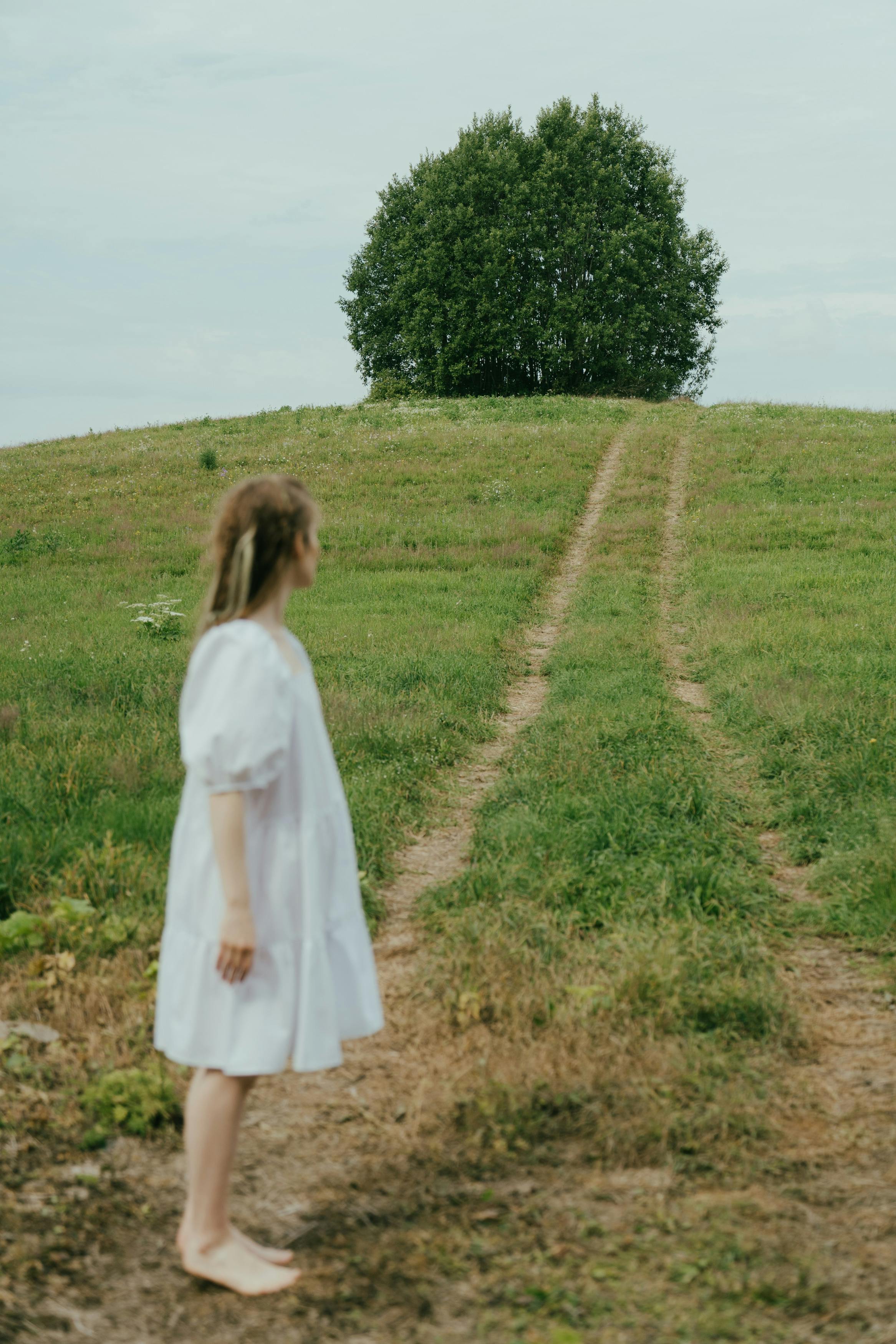 A Woman in White Dress Standing on Green Grass Field · Free Stock Photo