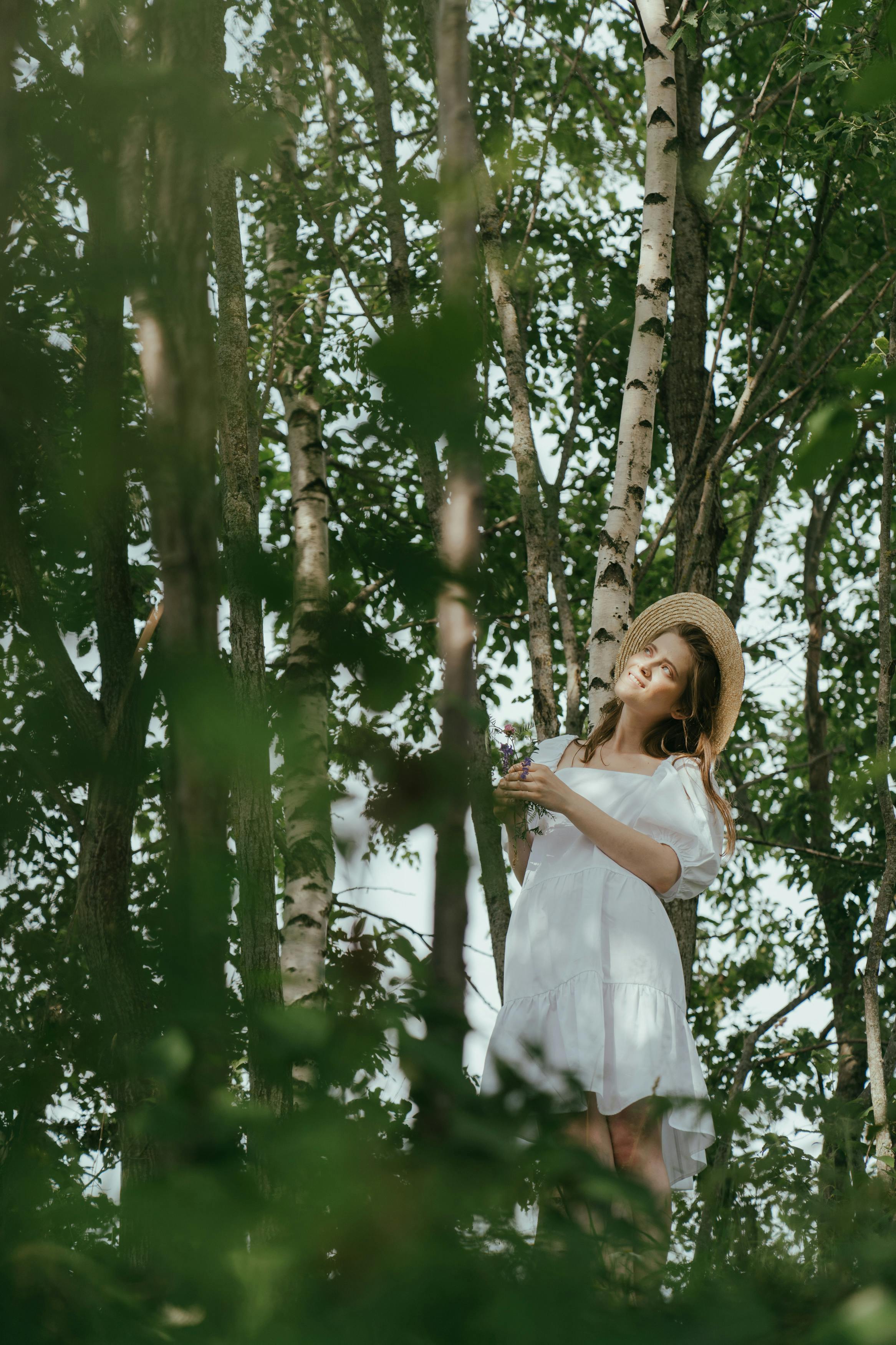 A Woman Standing in Between Trees in the Forest · Free Stock Photo