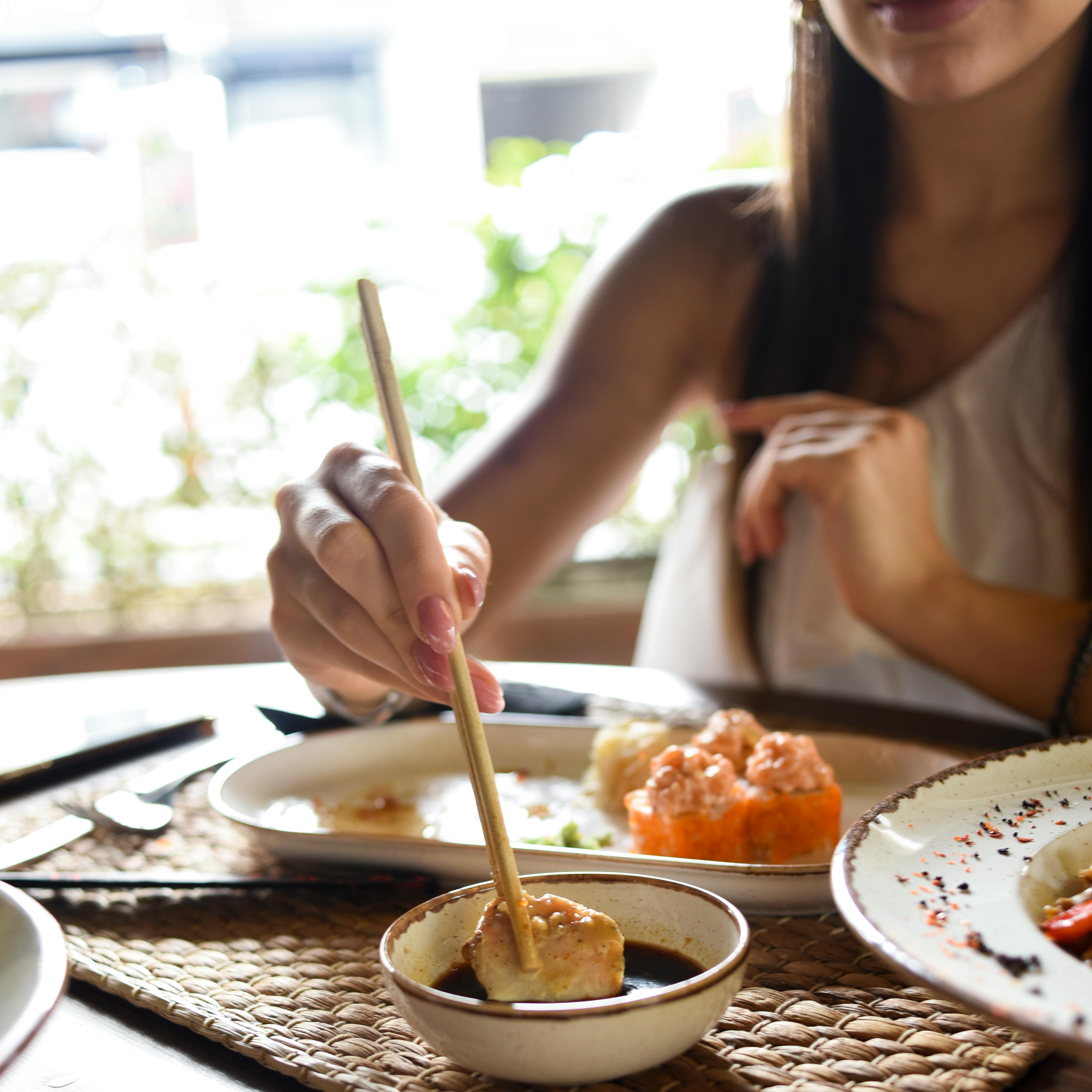 Woman in White Tank Top Holding Chopsticks · Free Stock Photo