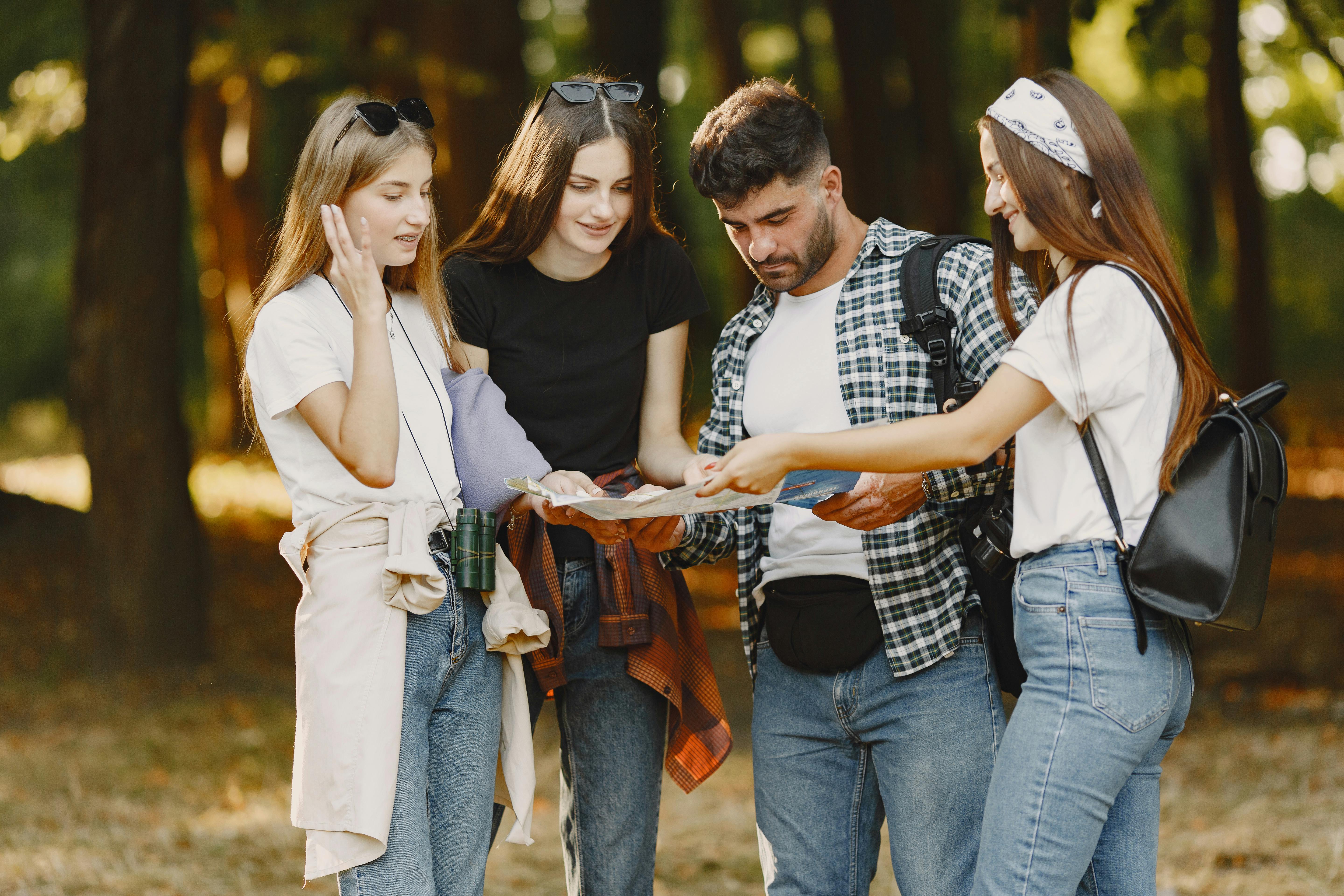 Friends Looking at a Map in a Forest · Free Stock Photo