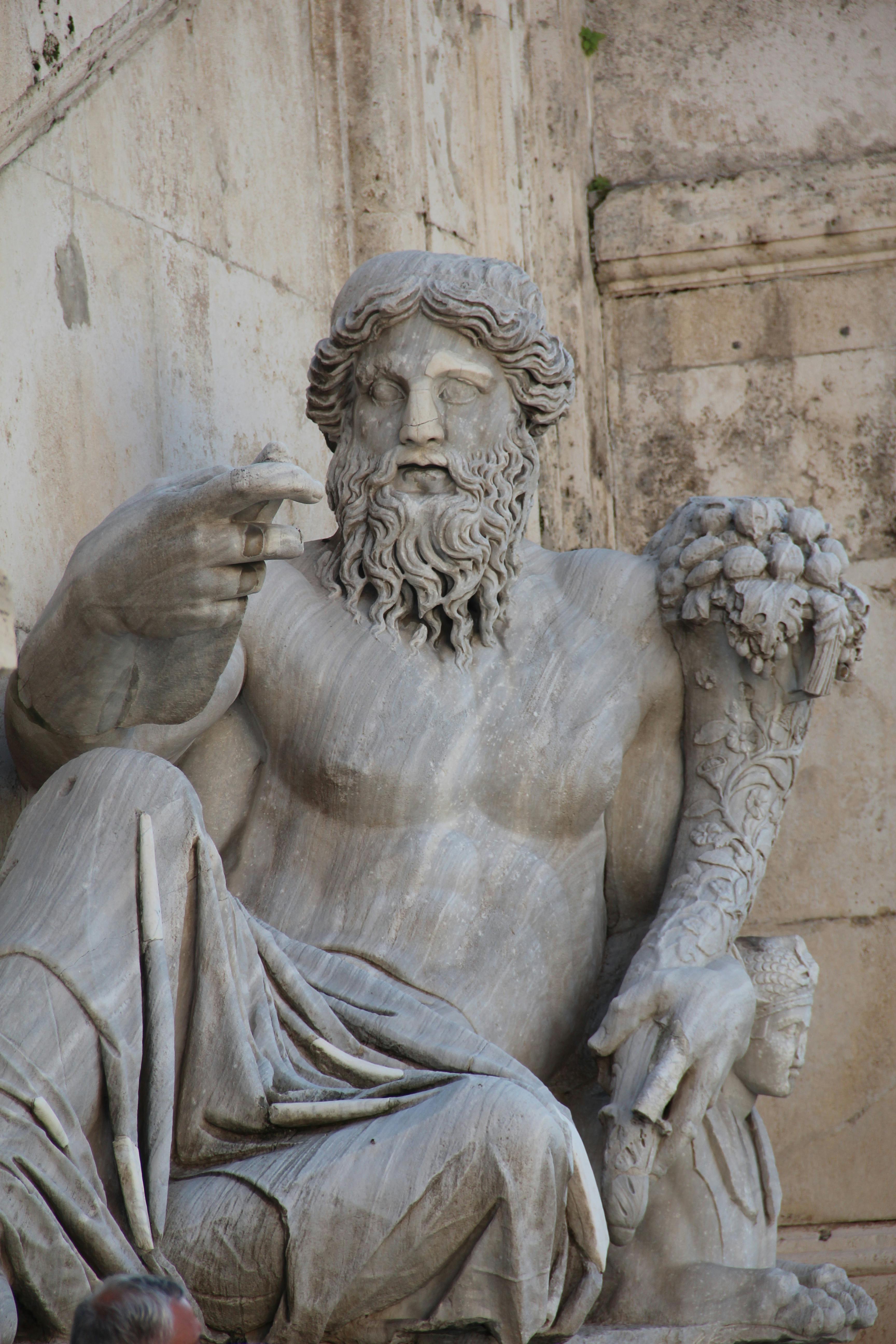 Stone Sculpture of a Bearded Man with a Decorative Horn · Free Stock Photo