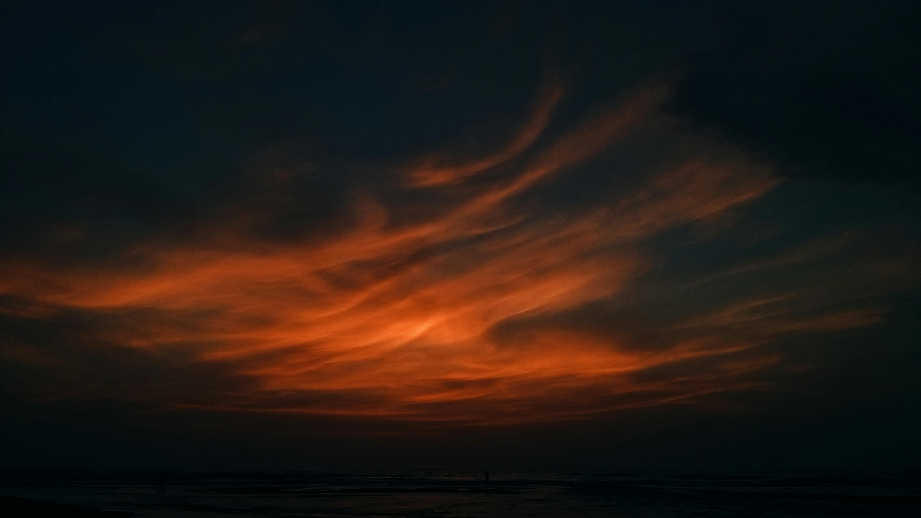 Low Exposure Photo of a Sunset Over a Sea · Free Stock Photo
