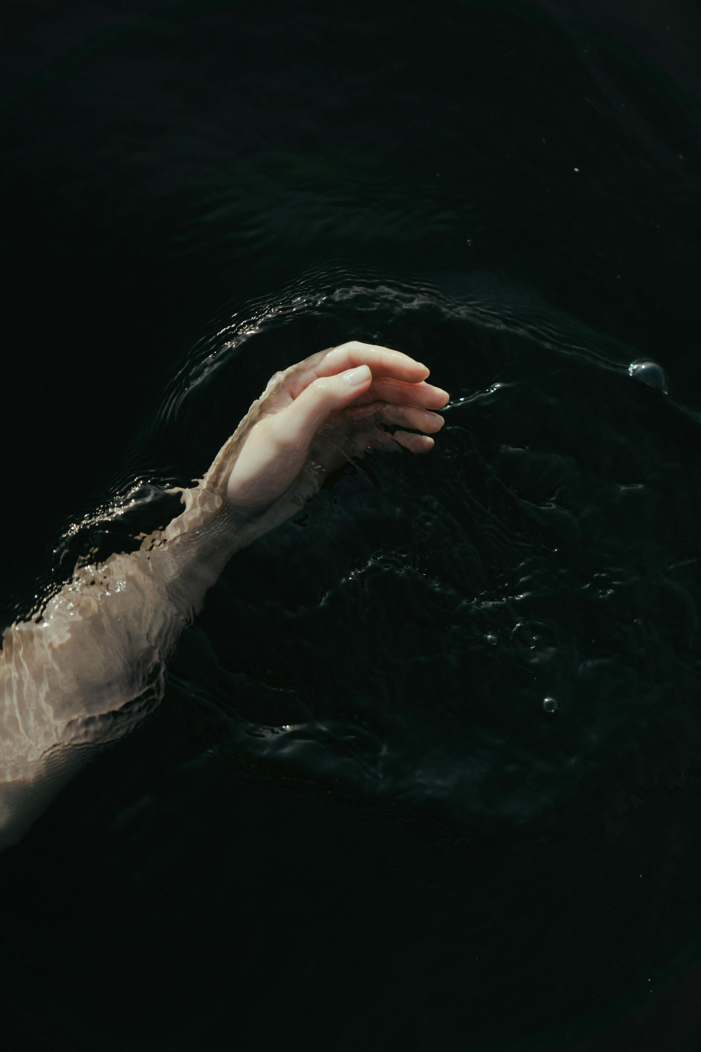 Photo of a Person's Hand on Water · Free Stock Photo