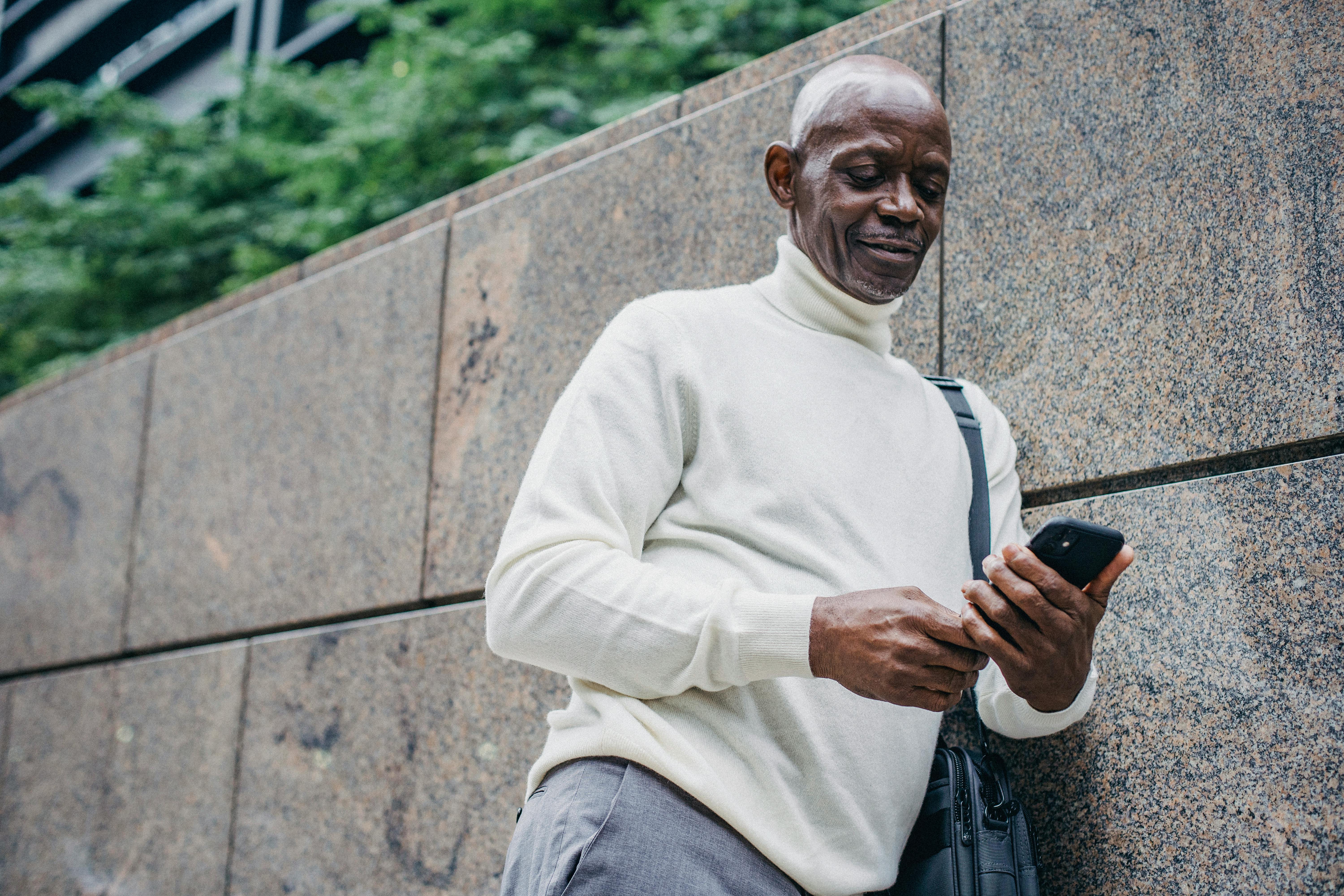 Black man using mobile phone on street · Free Stock Photo
