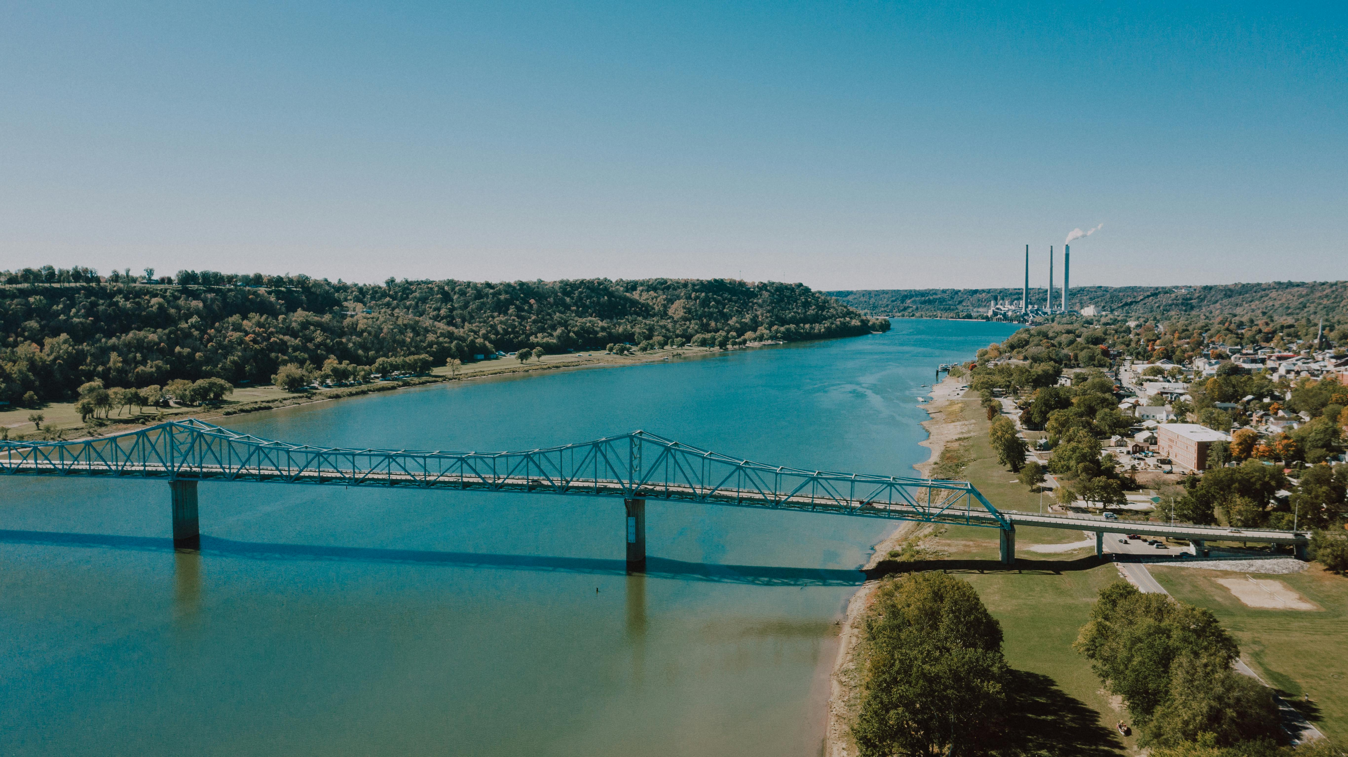 Bridge over city river under blue sky · Free Stock Photo