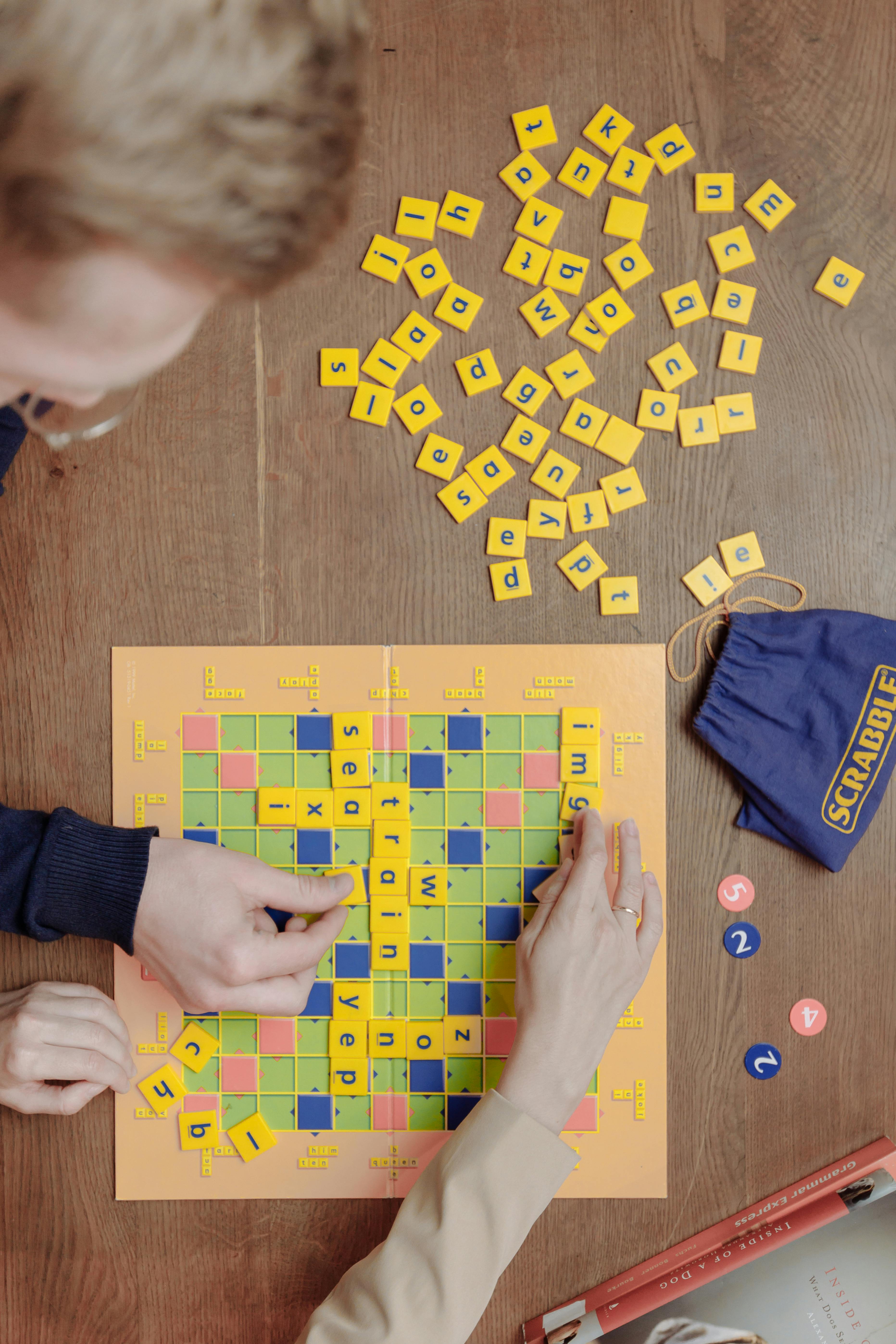 High-Angle Shot of Two People Playing Scrabble · Free Stock Photo