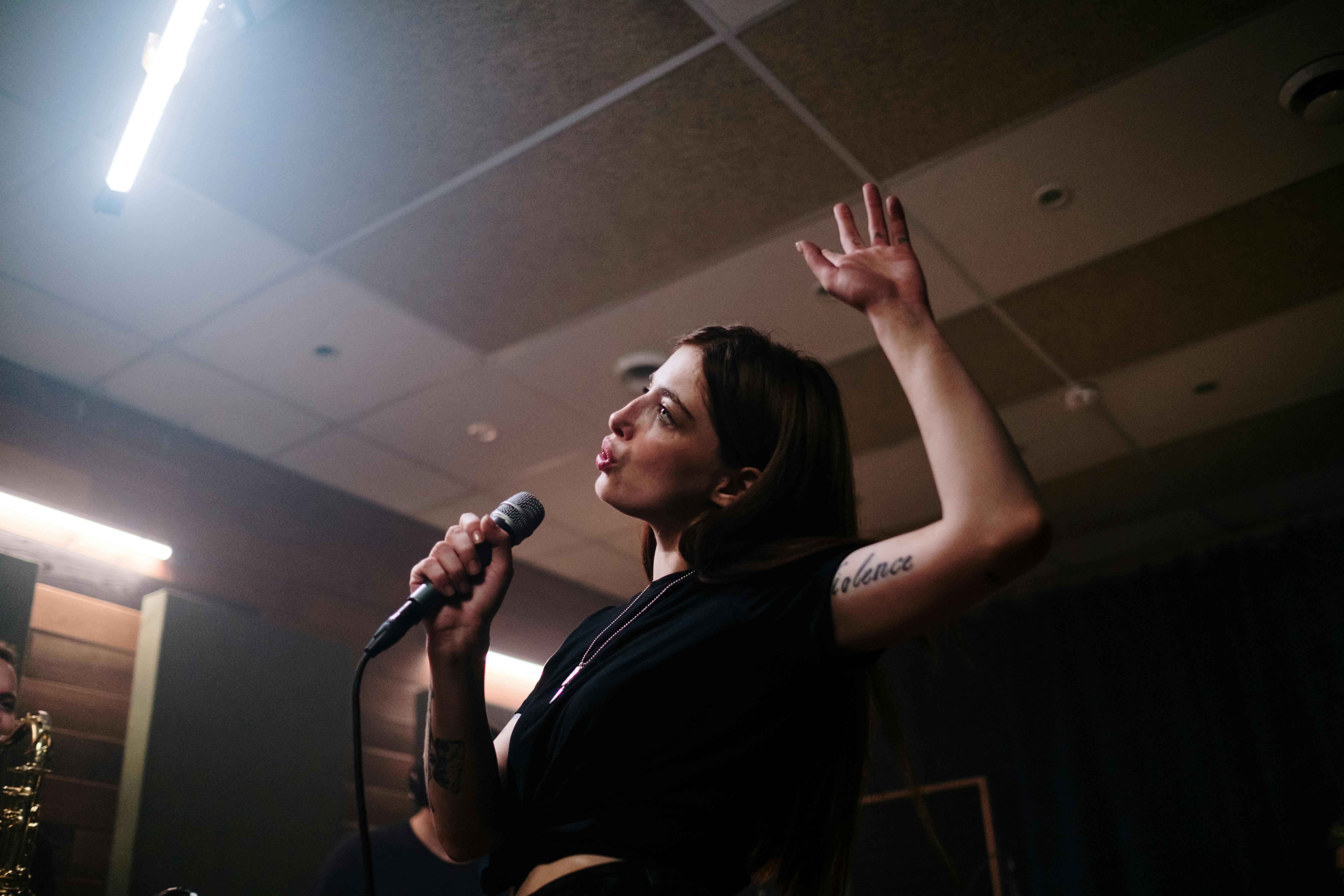 Low-Angle Shot of Woman Singing Passionately · Free Stock Photo