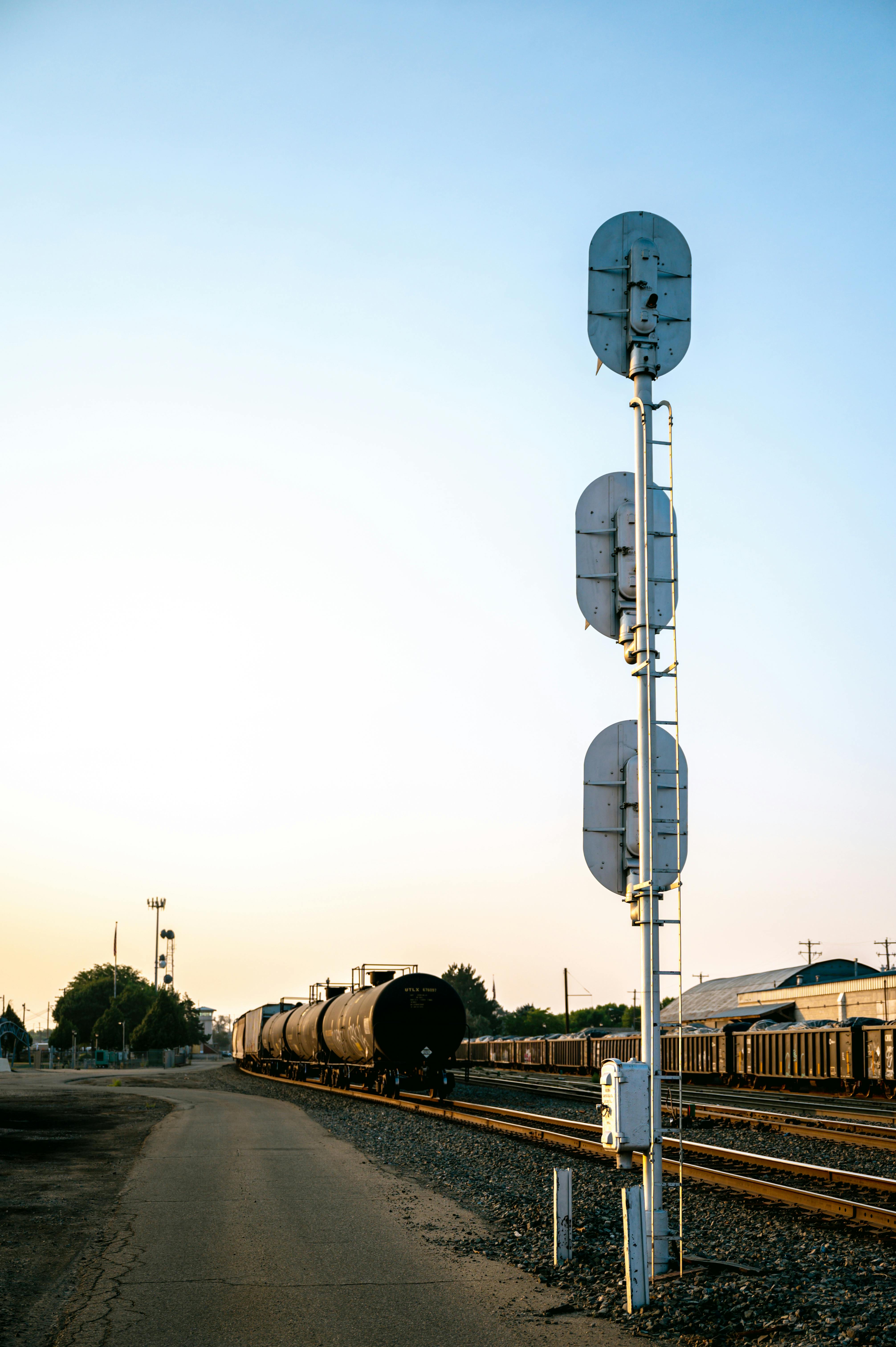 Asphalt road near railroad with trains · Free Stock Photo