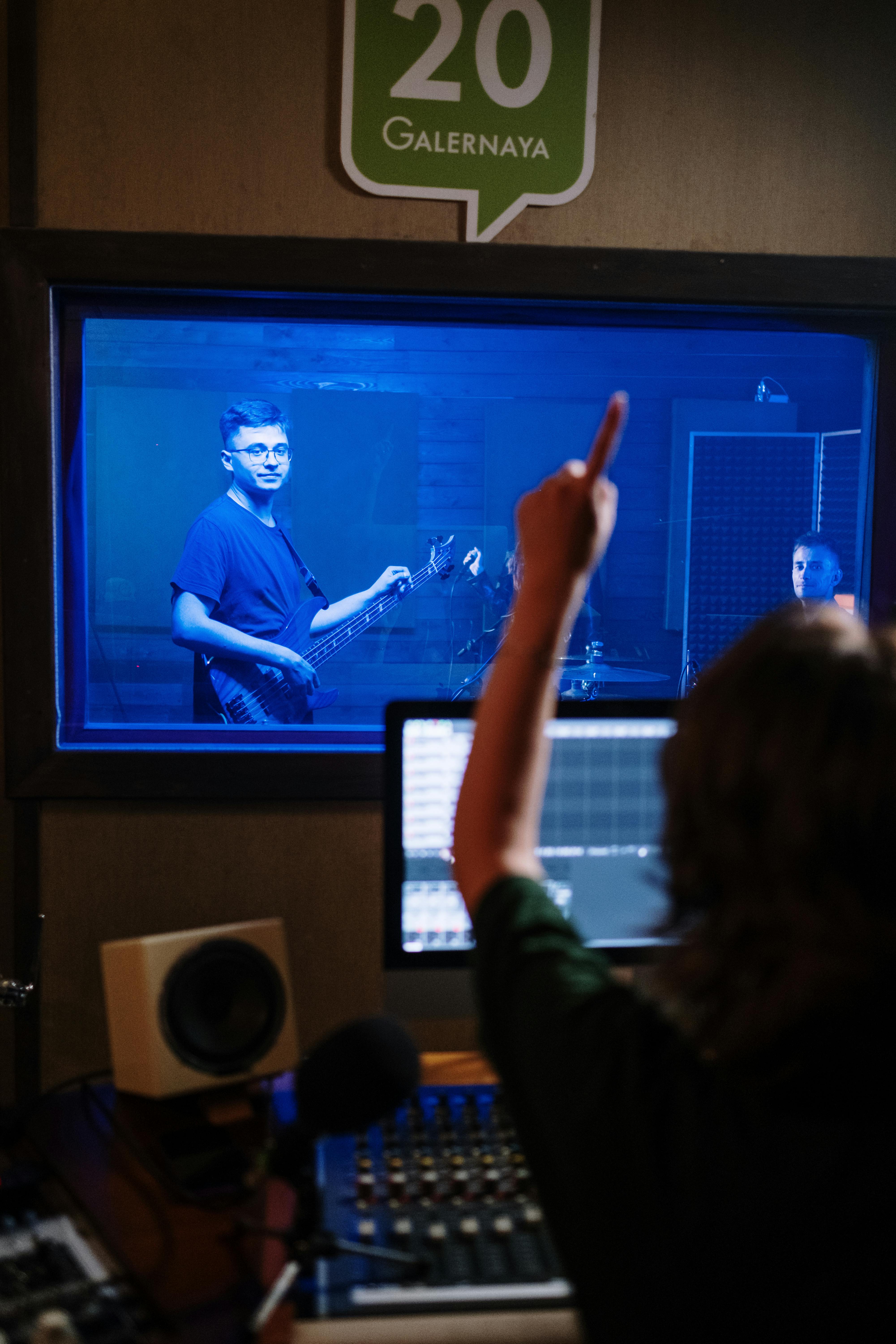 A Man Holding a Bass Guitar Inside a Recording Studio · Free Stock Photo