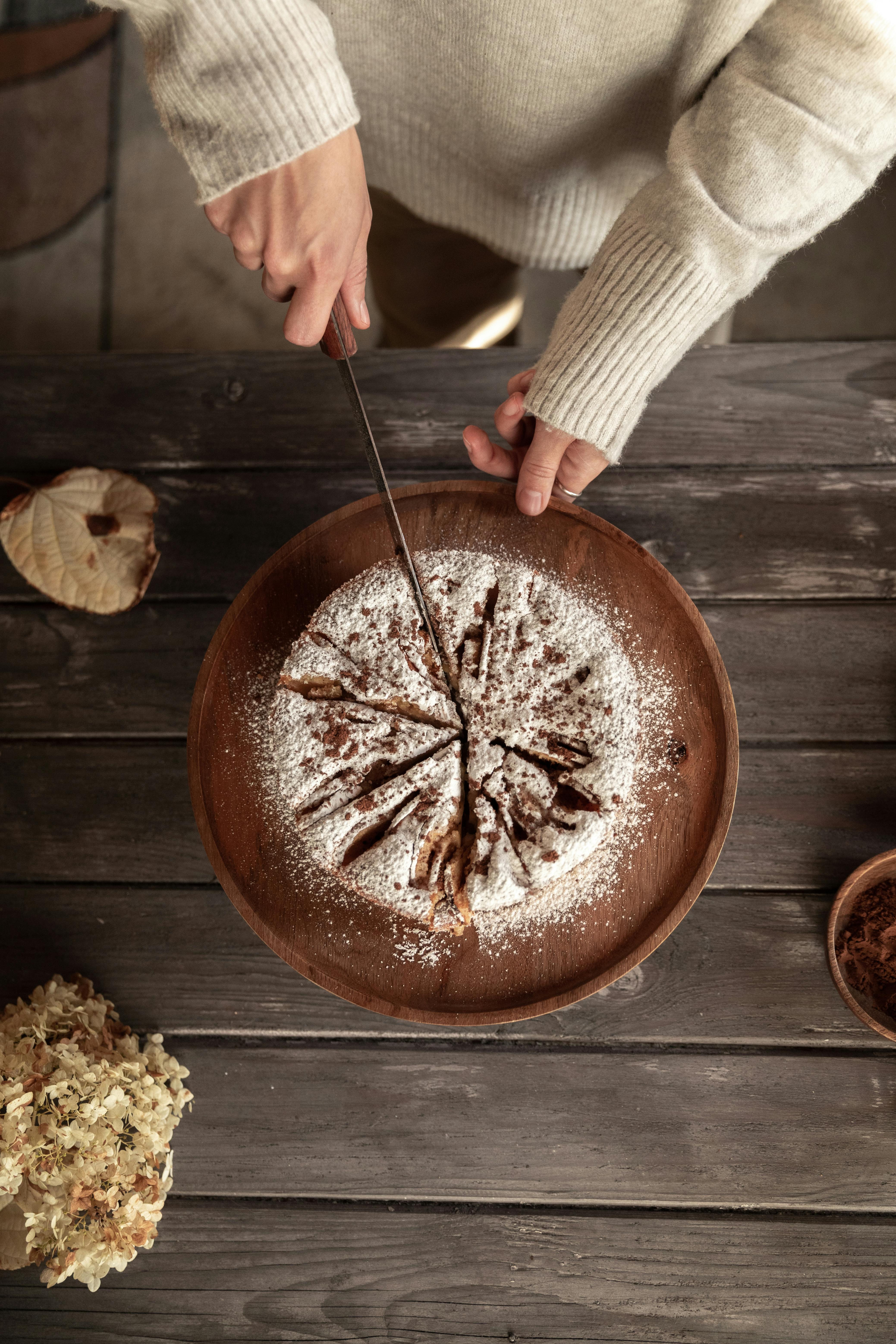 Close-Up Photo of a Person's Hand Slicing a Cake · Free Stock Photo
