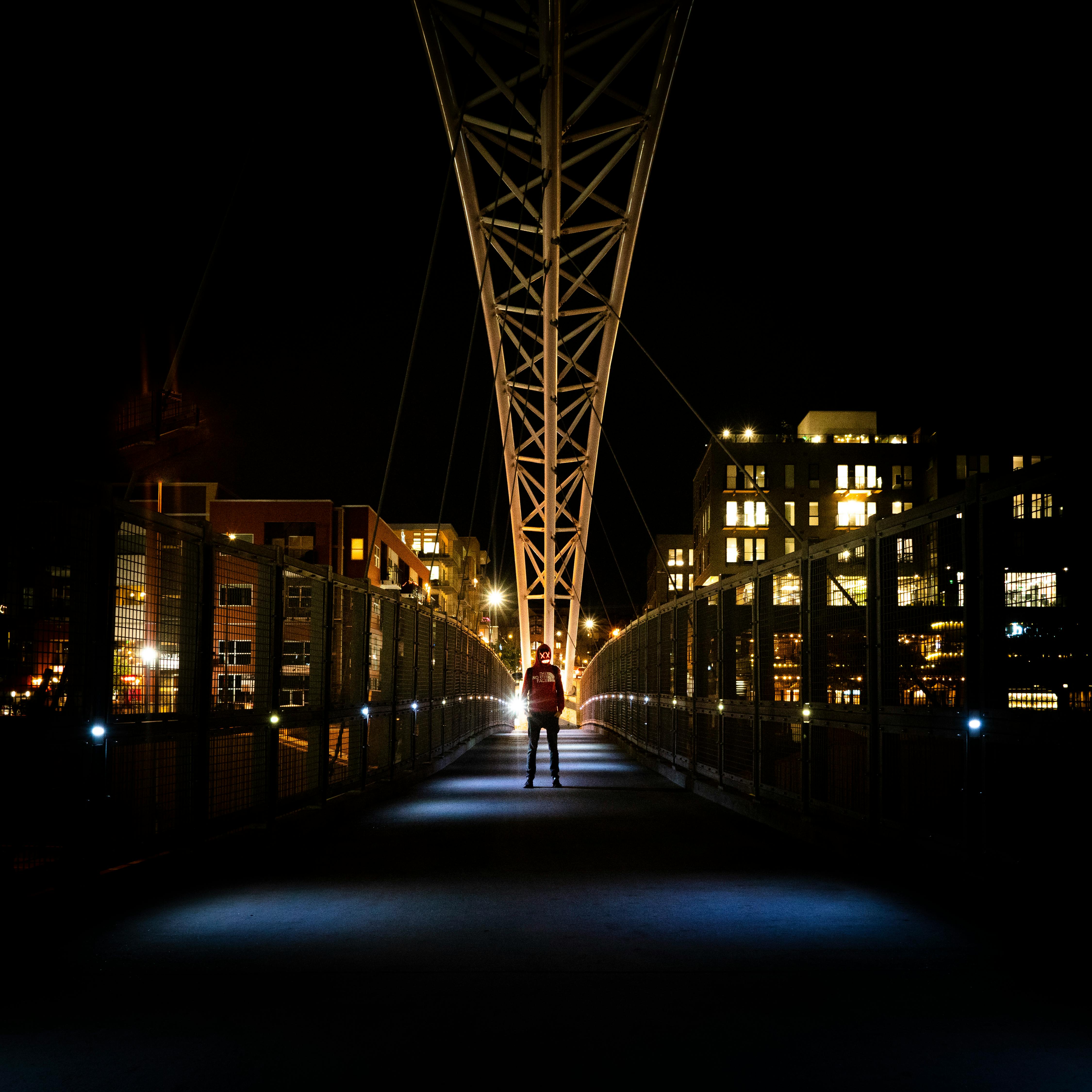 Man Standing on The Bridge during Night Time · Free Stock Photo