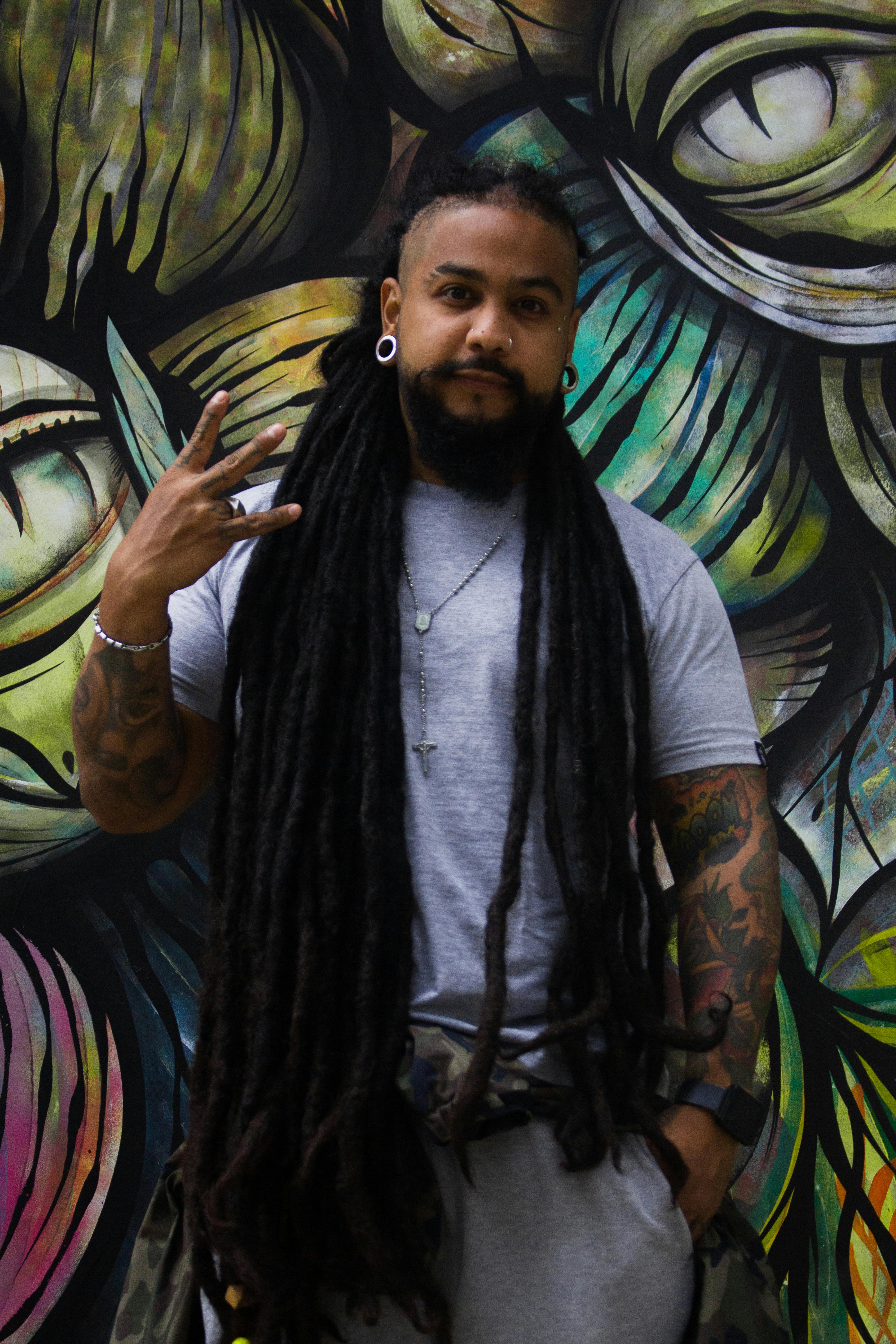 A Tattooed Man with His Hands in His Pockets · Free Stock Photo