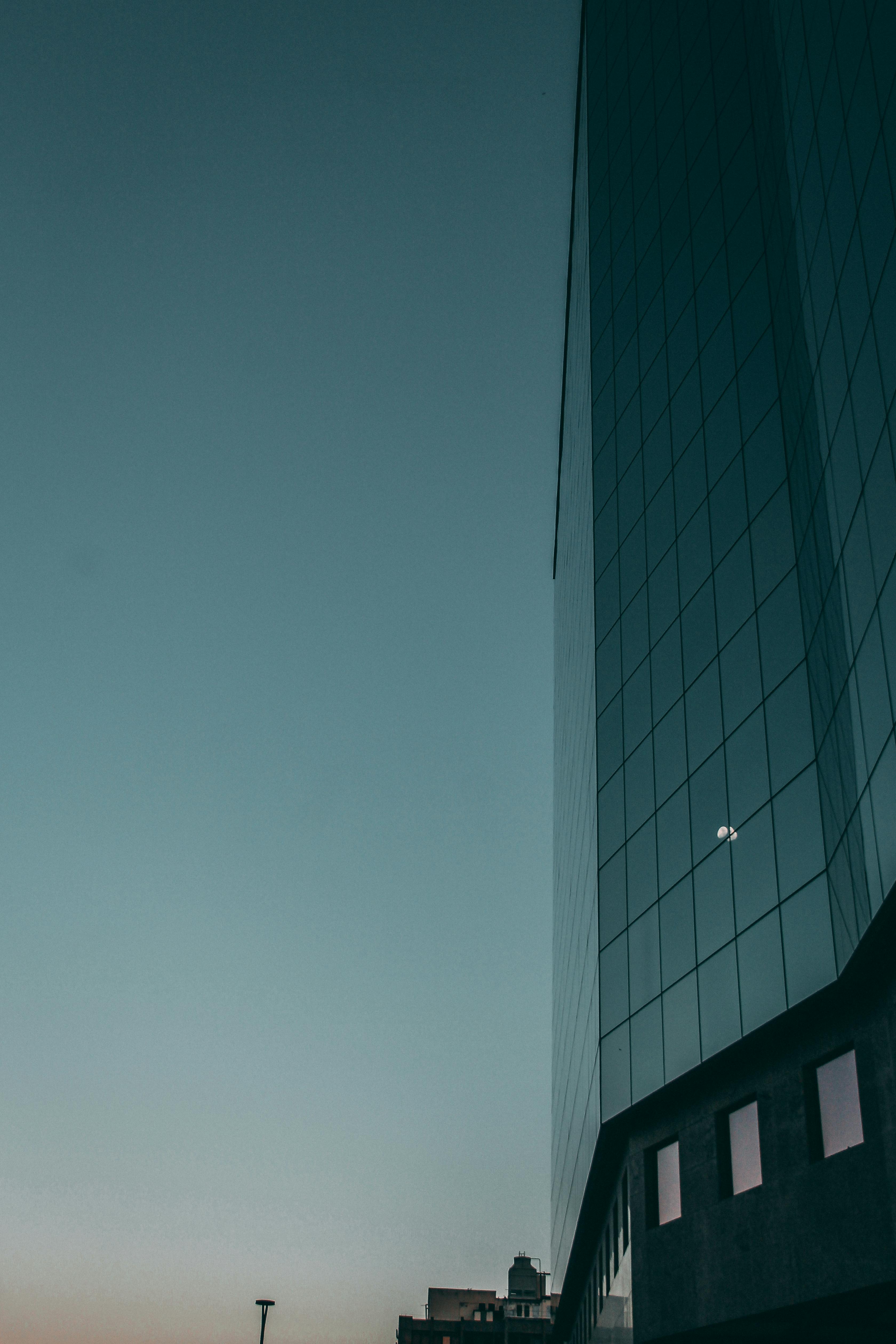 A High Rise Building With Green Glass Windows · Free Stock Photo