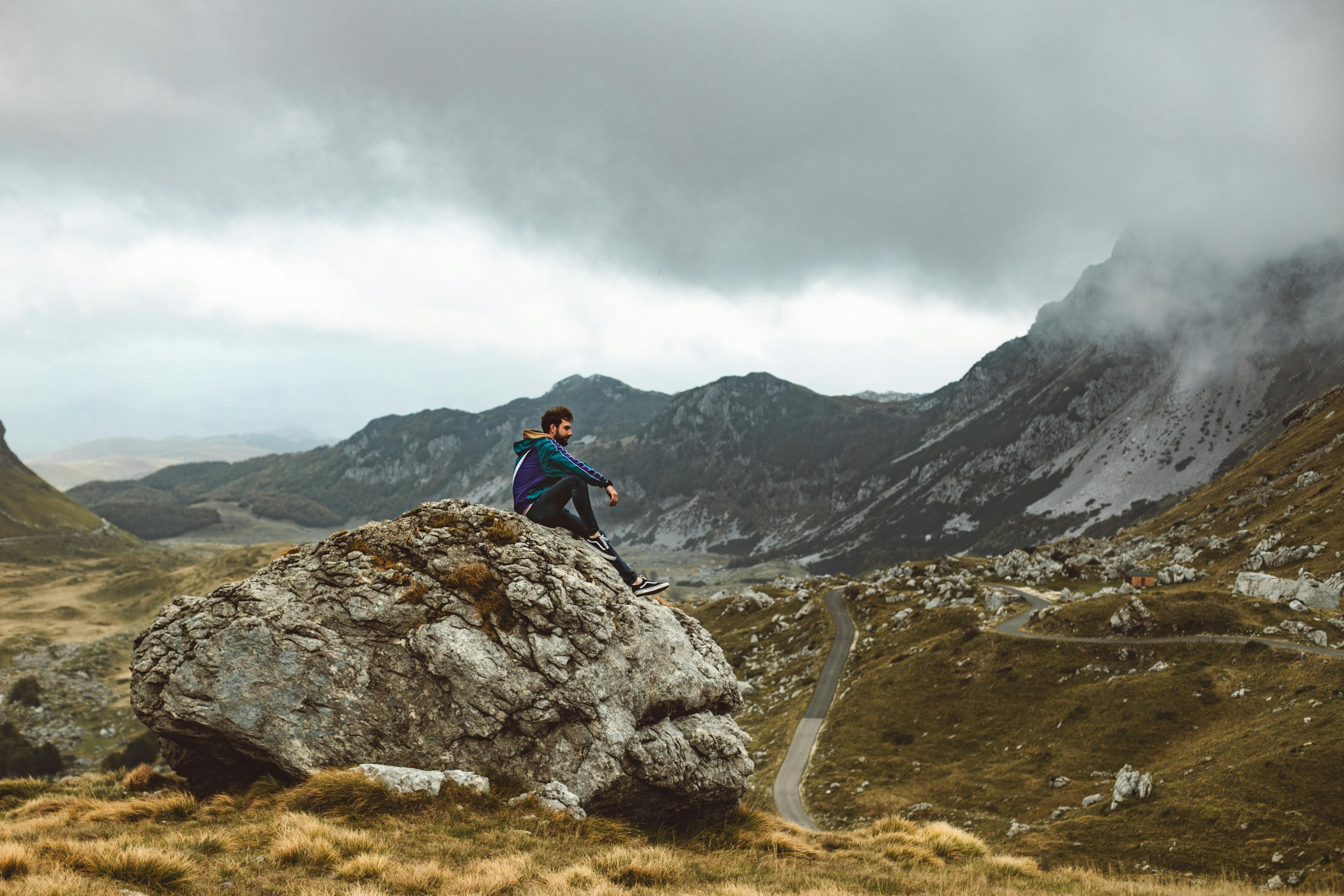 Male Mountain Climber sitting on a Boulder · Free Stock Photo