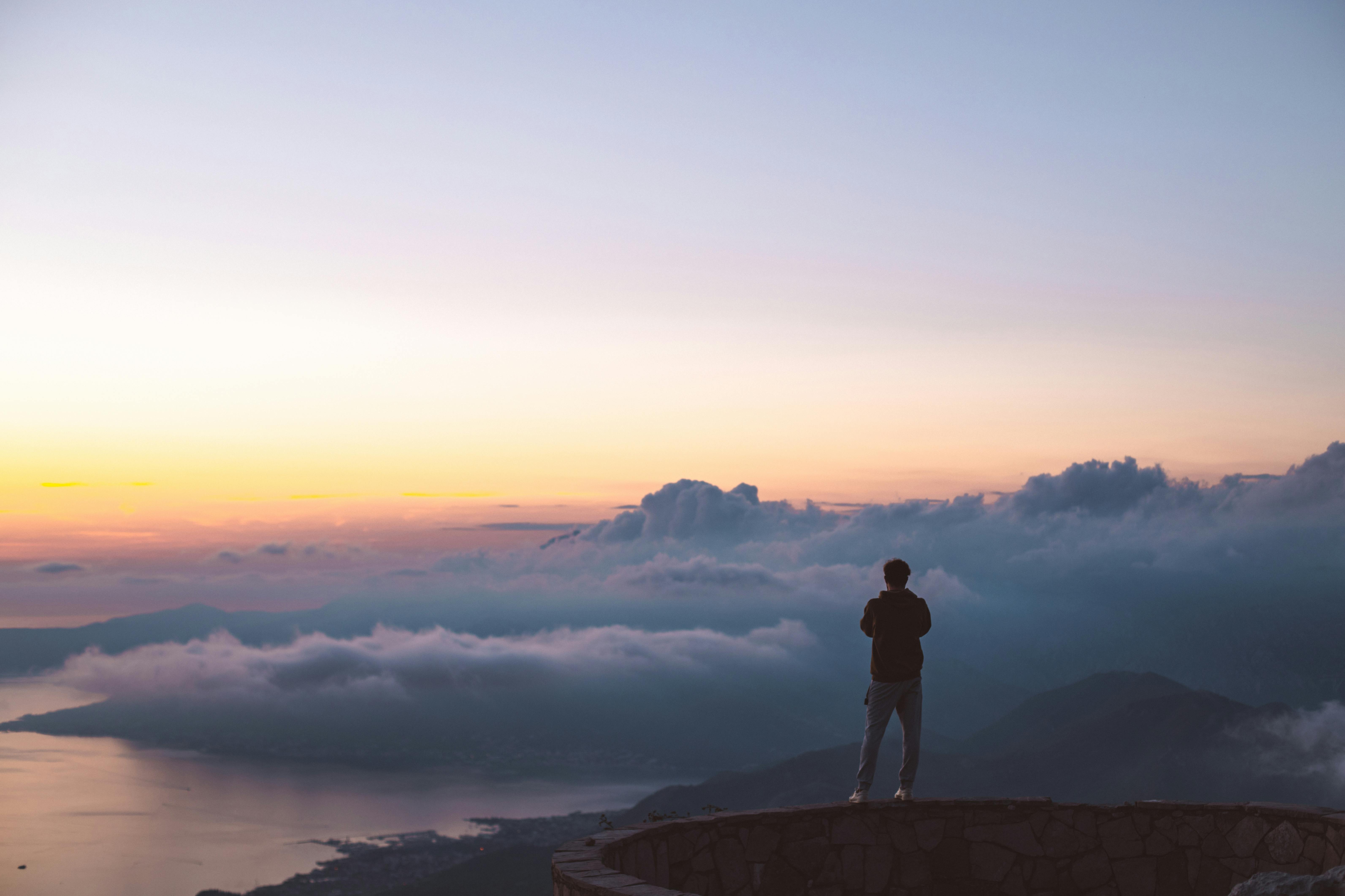 Man Standing on Rock Formation during Sunset · Free Stock Photo