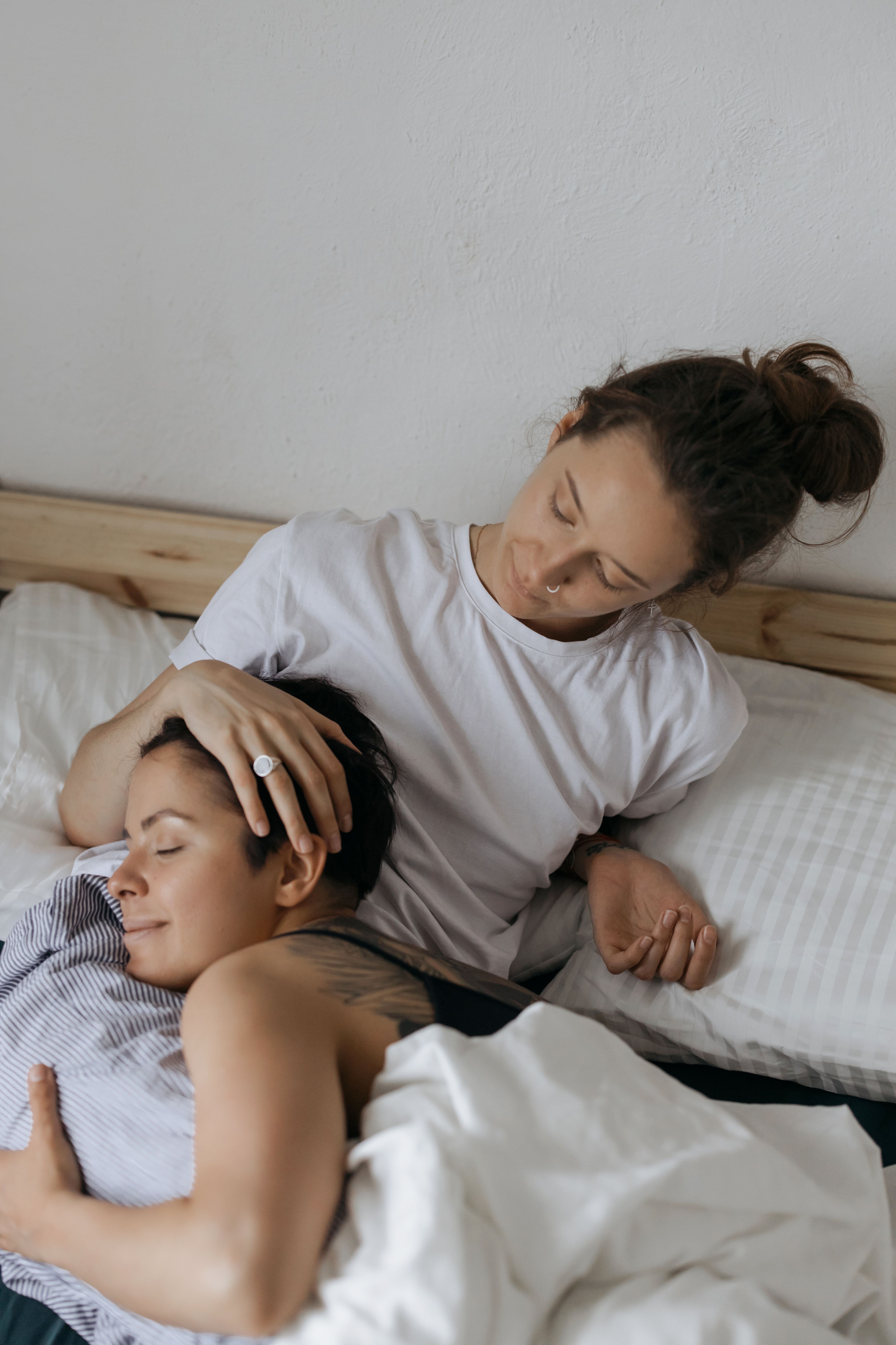 Women Lying Down on Bed and Hugging · Free Stock Photo