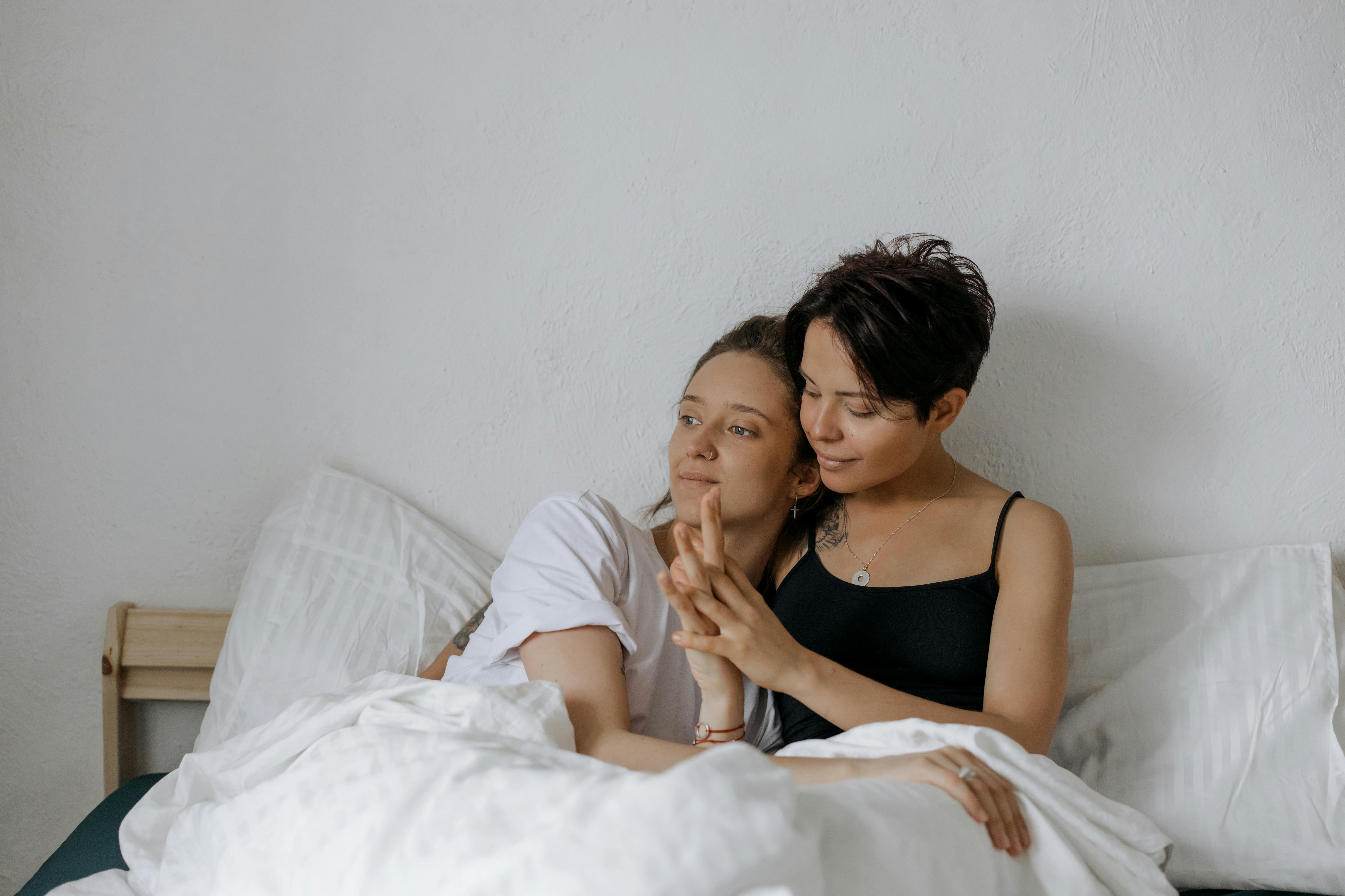 Women Lying Down on Bed and Hugging · Free Stock Photo